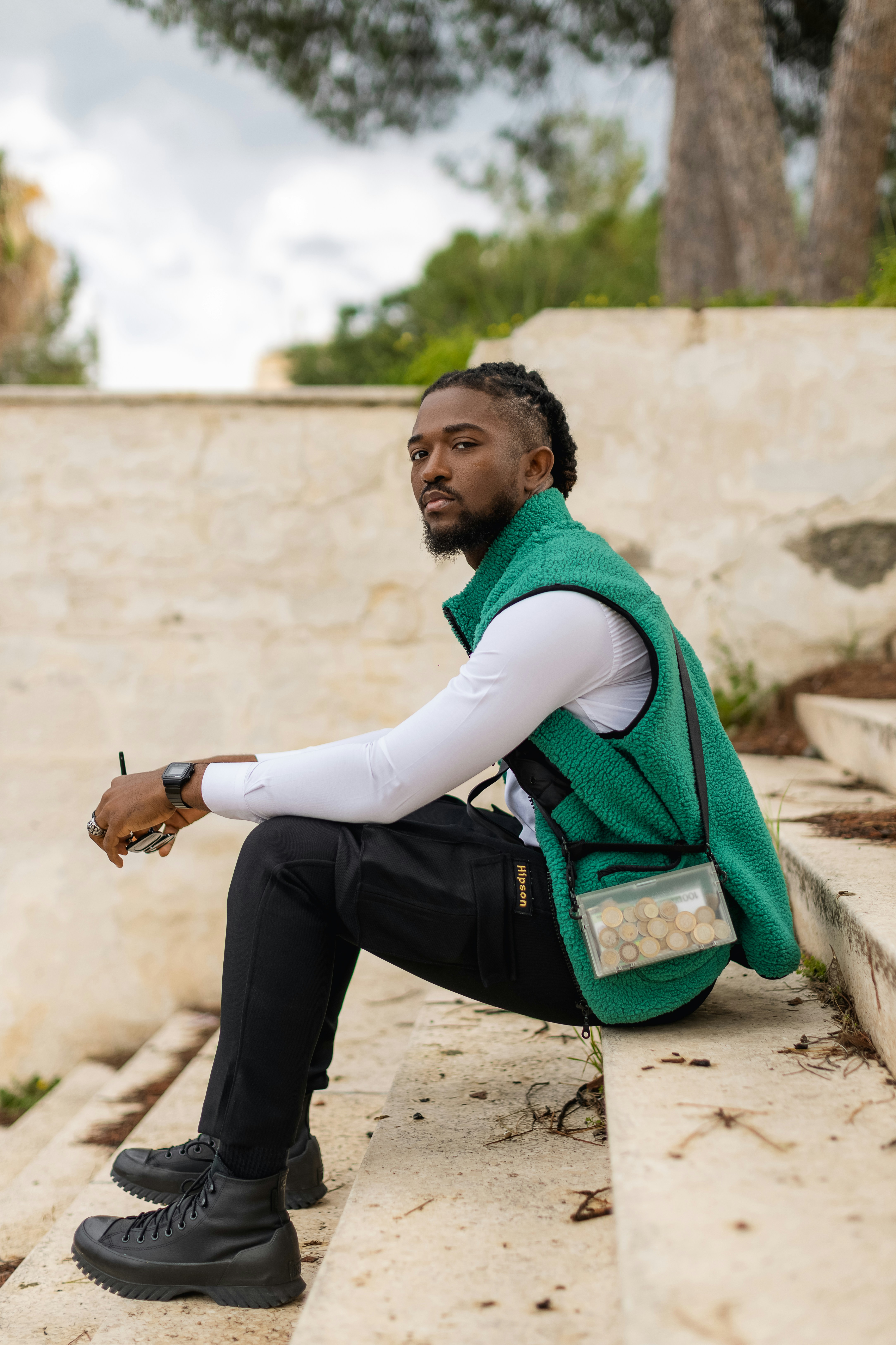 A man in a green vest sitting on a ledge photo – Free Cyprus Image on ...