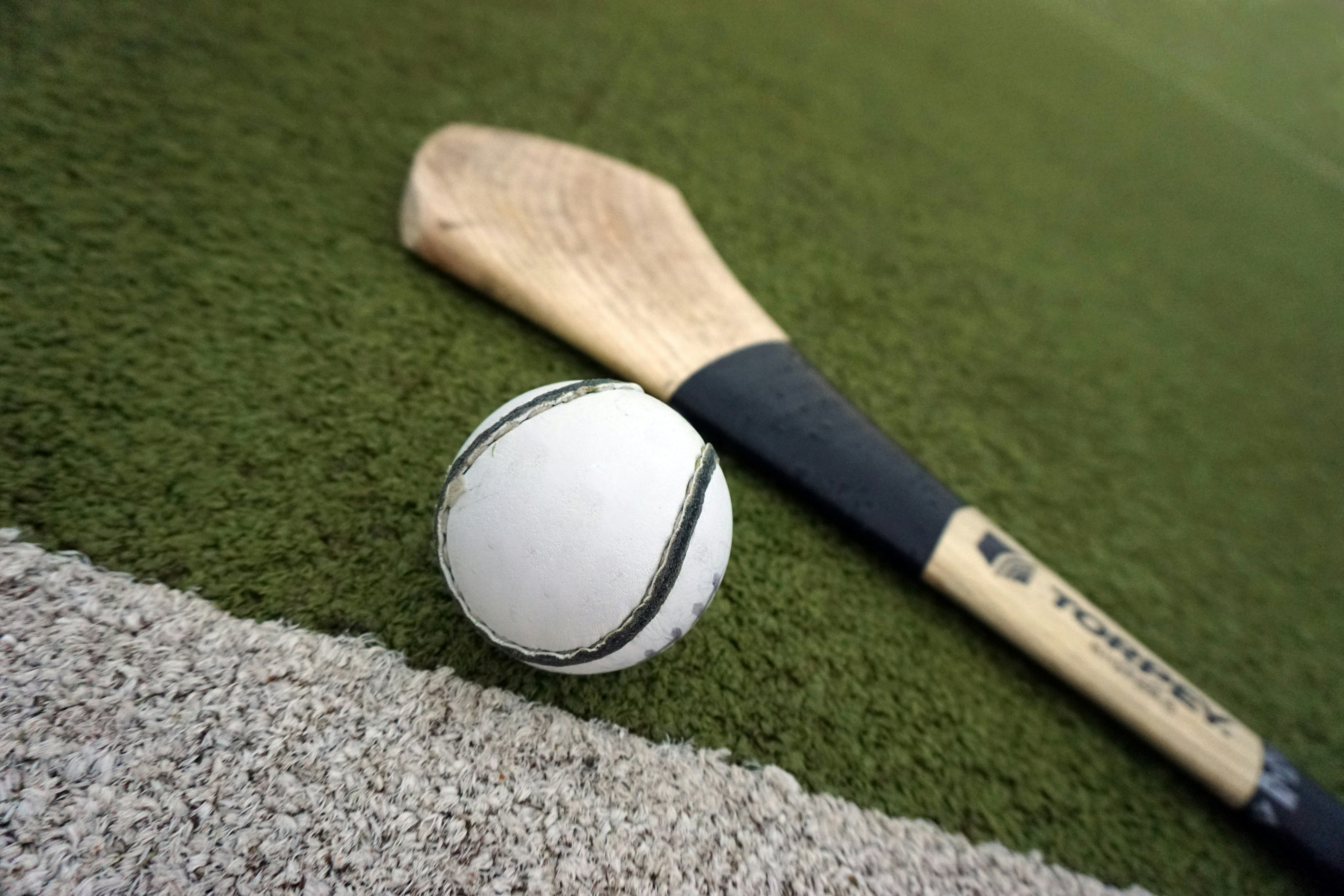 A baseball bat and a ball laying on the ground photo – Free Hurling ...