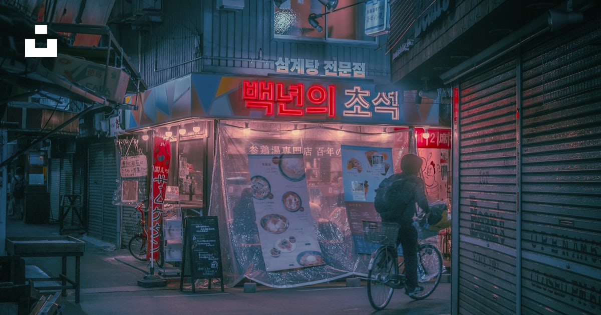 밤에 자전거를 타고 거리를 내려가는 남자 사진 Unsplash의 무료 오사카 이미지