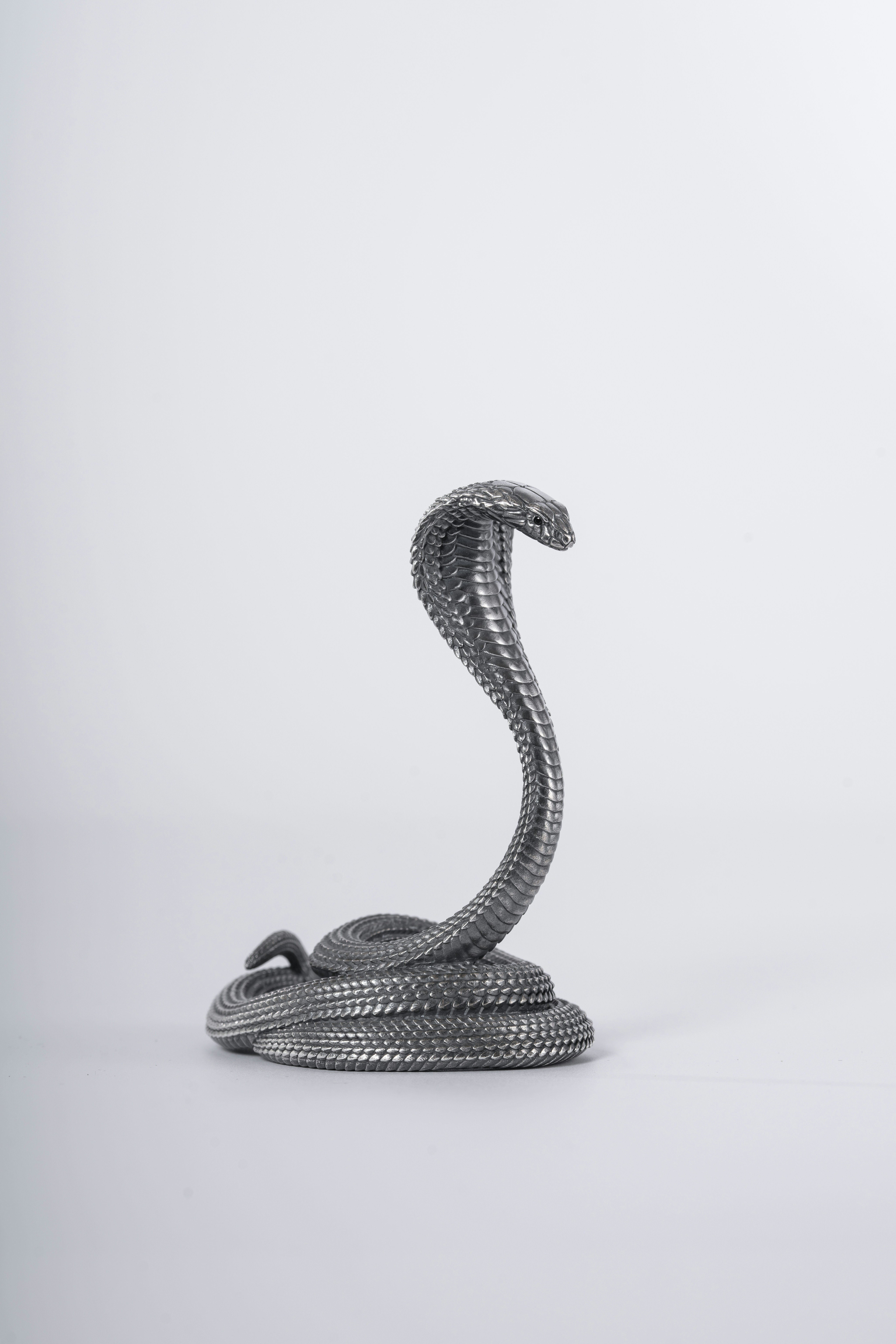 A snake statue sitting on top of a white surface photo – Free Animal ...