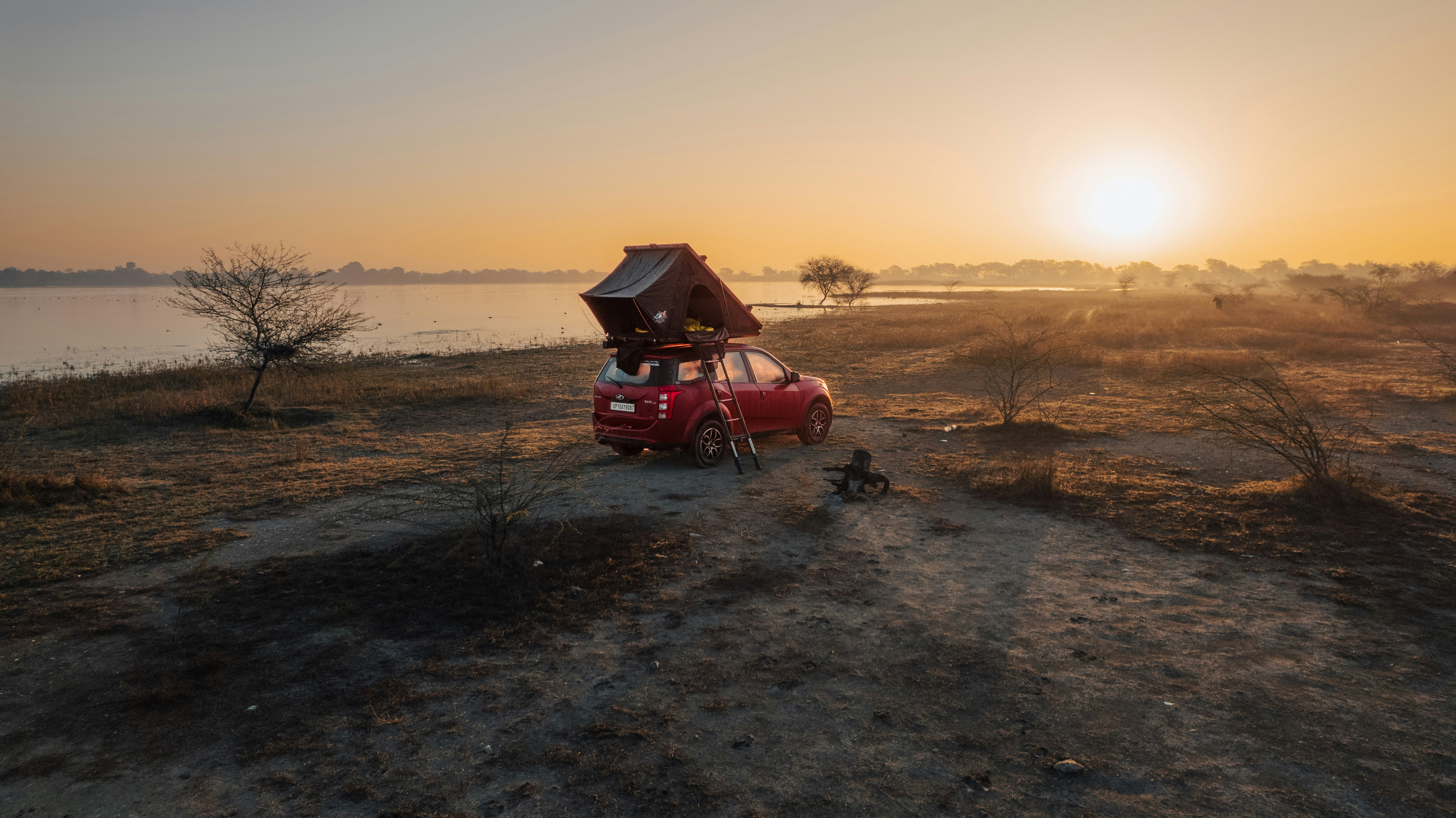 a car parked on a dirt road next to a body of water