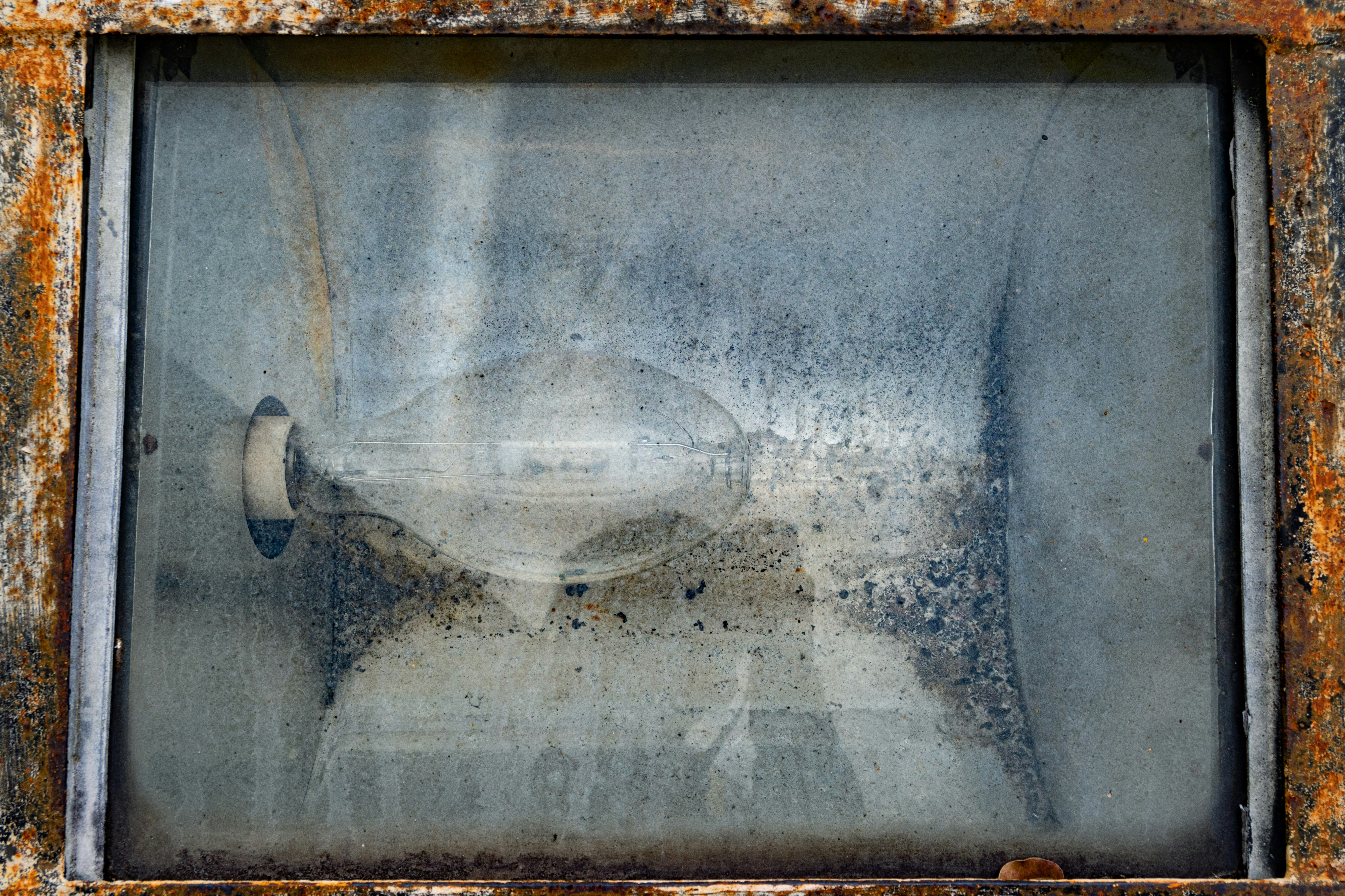 a rusted metal frame with a bowl on it