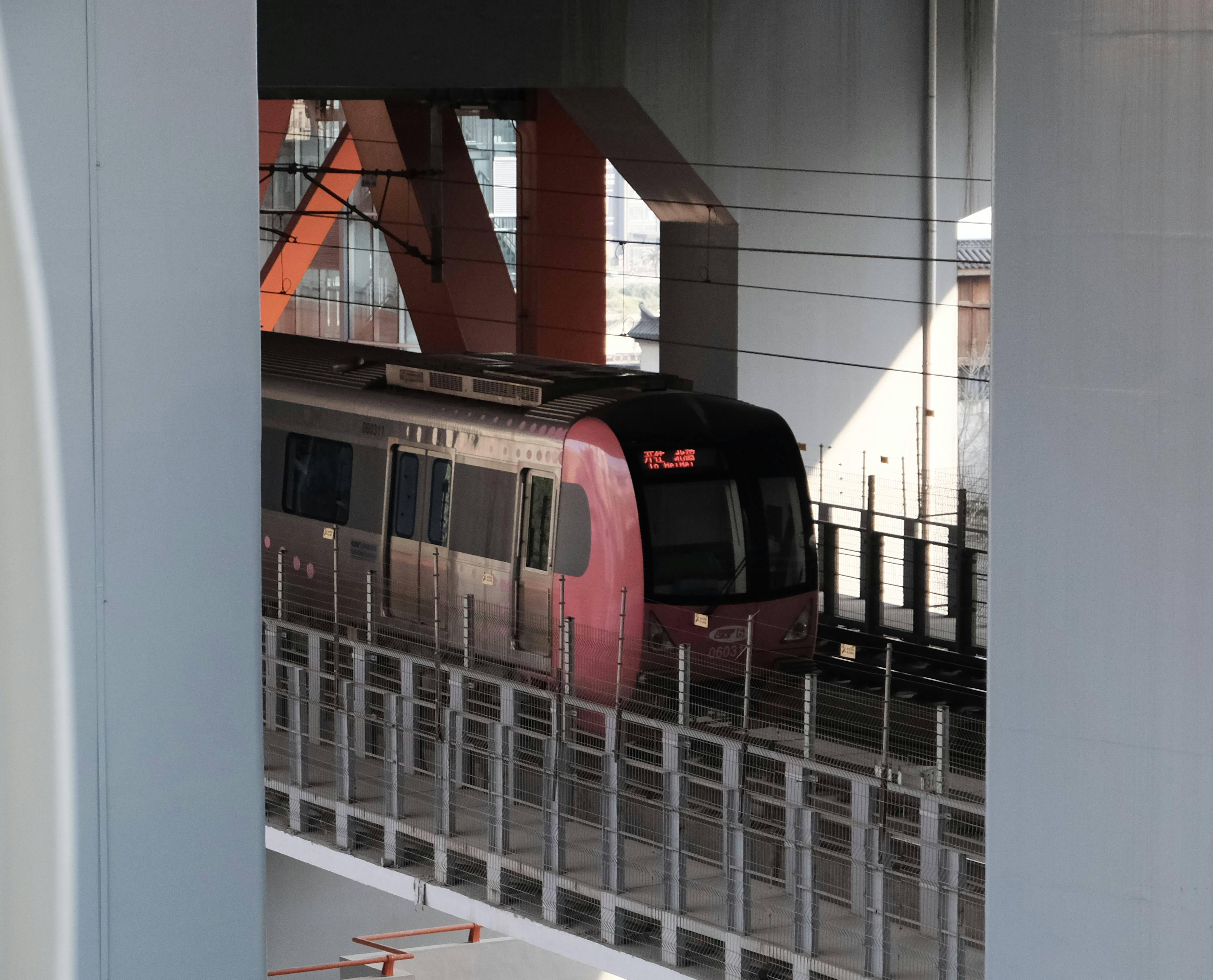 A train traveling through a train station next to tall buildings photo ...