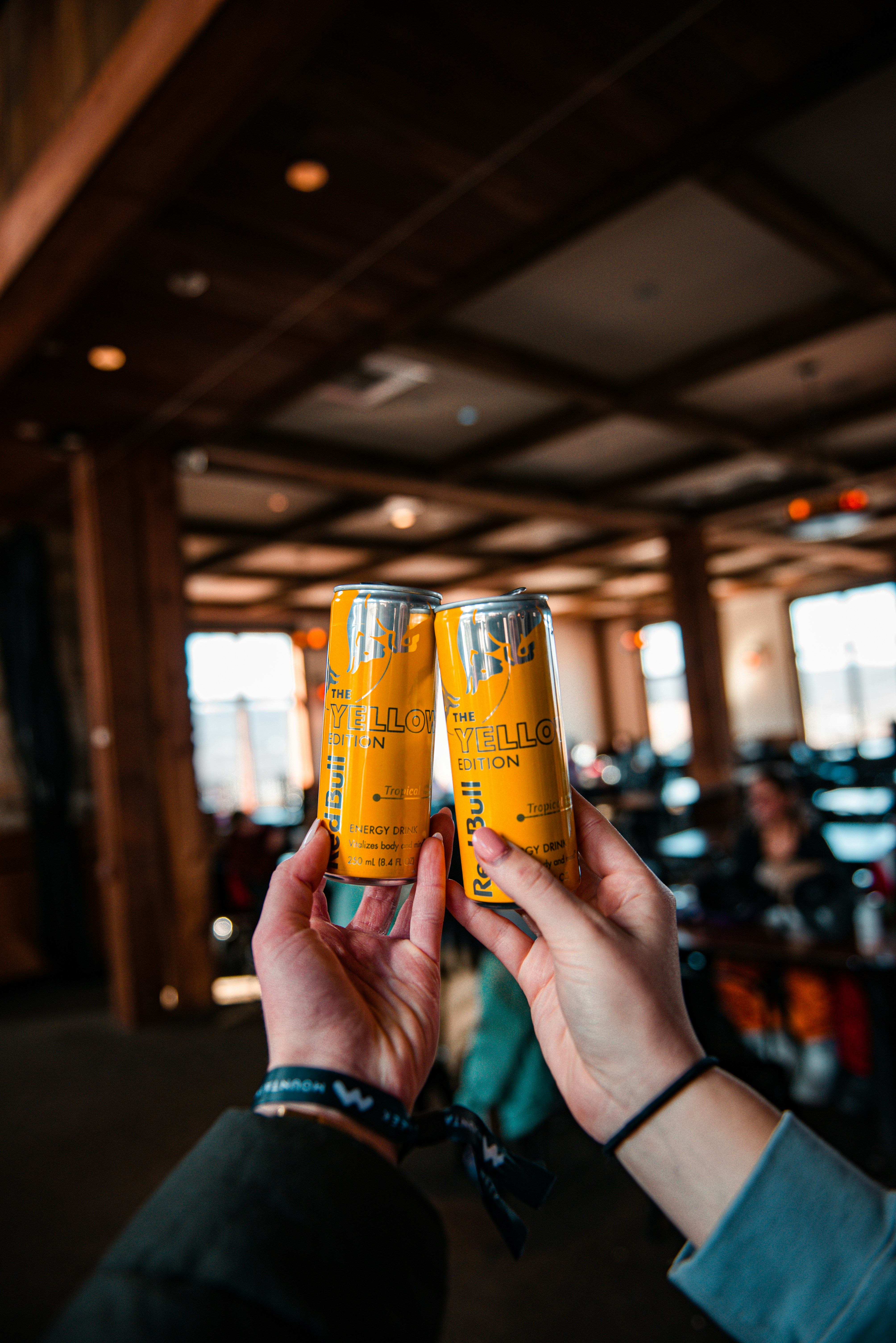 a person holding two cans of beer in their hands