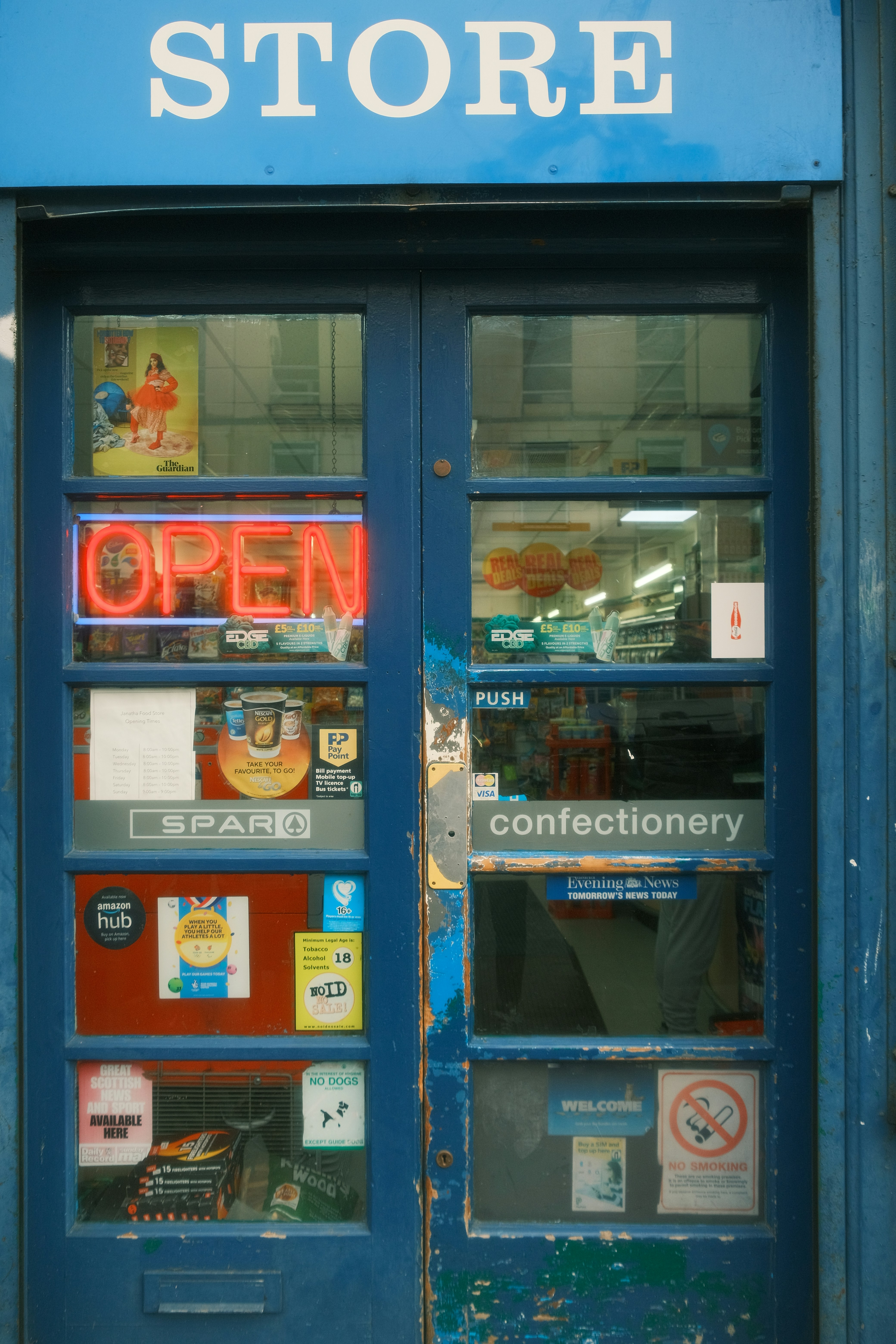A blue store front with a neon sign in the window photo – Free Building ...