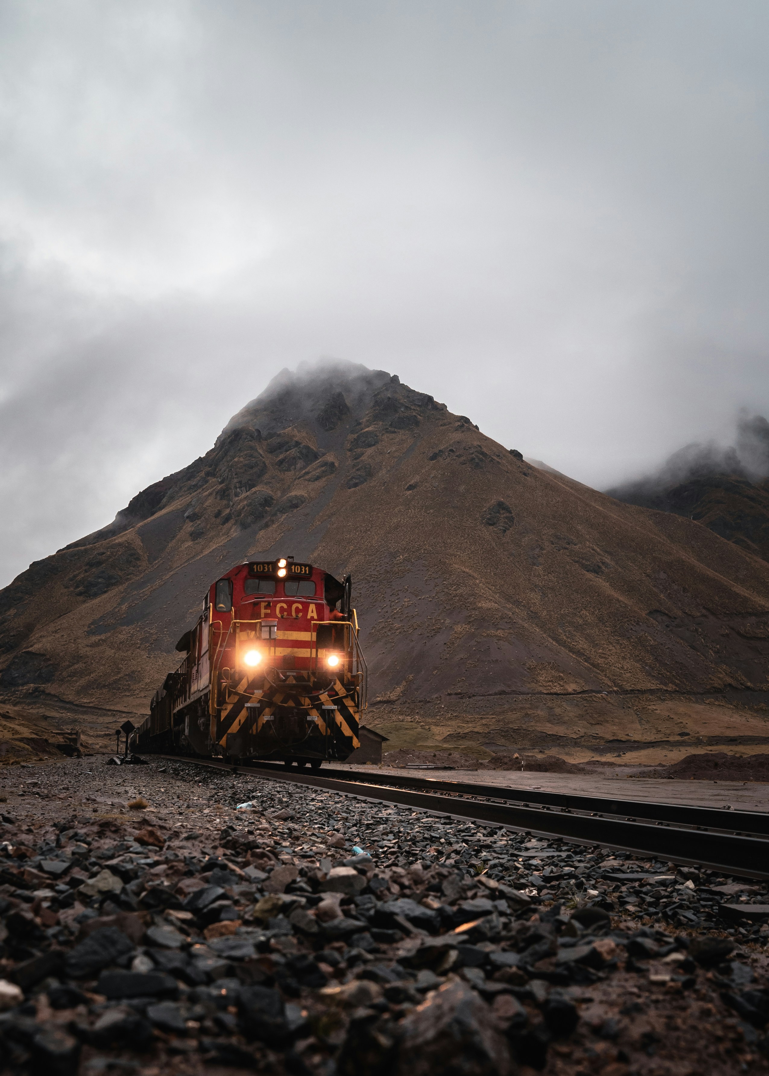 Crimson Locomotive at the Foot of a Mist-Wrapped Peak