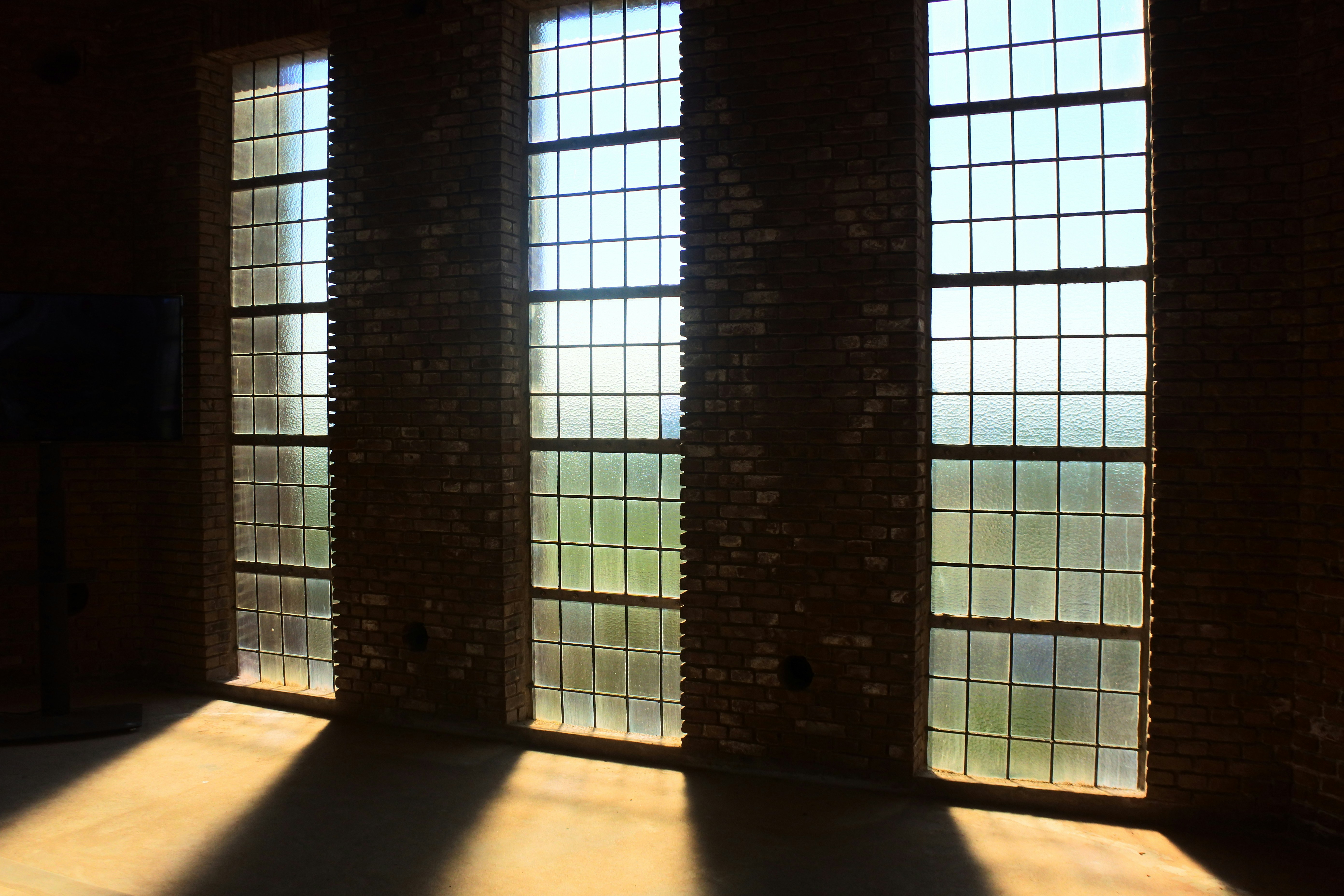 Sunlit Brick Gallery: Vertical Glass Windows Casting Long Shadows