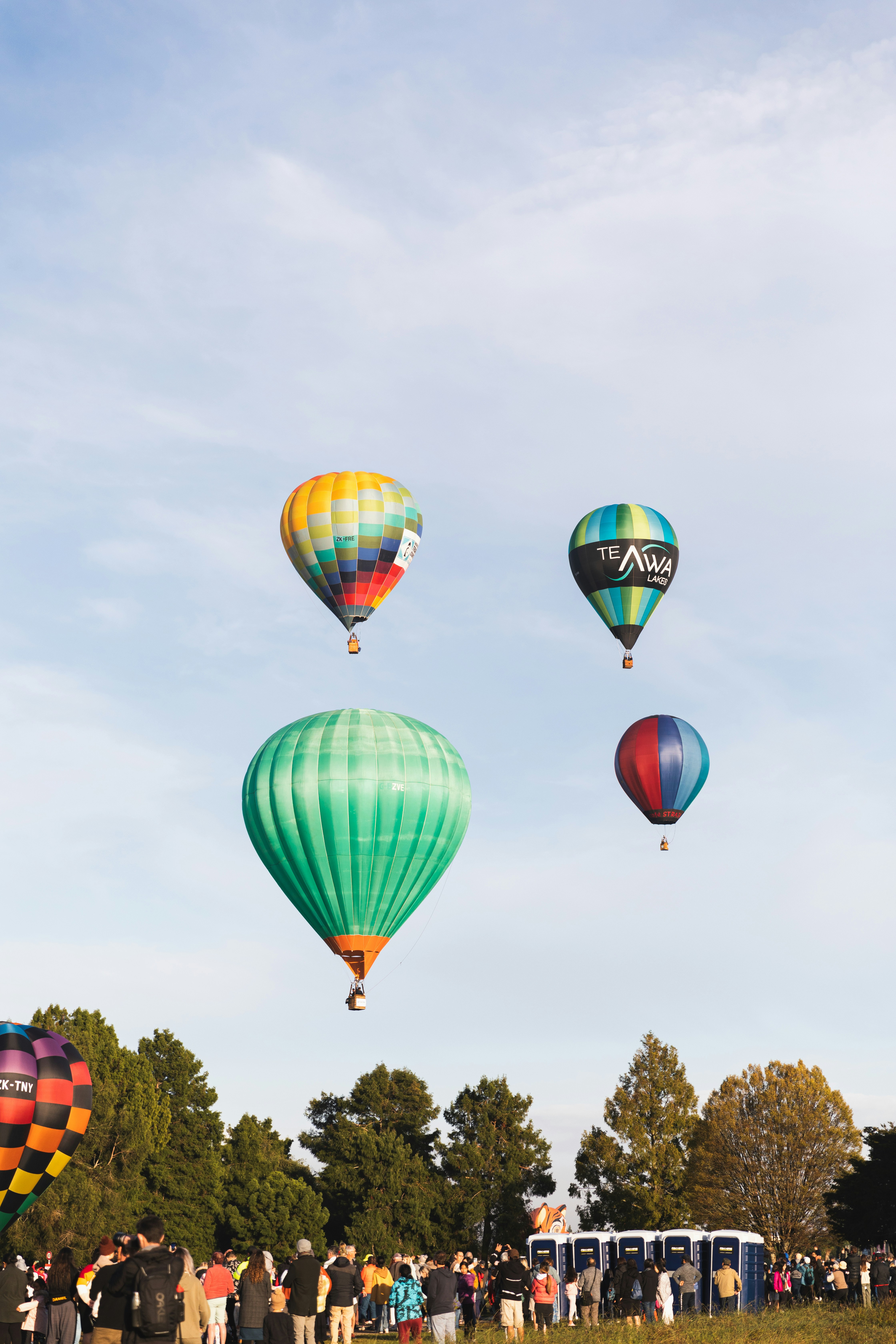 A group of people watching hot air balloons in the sky photo – Free ...