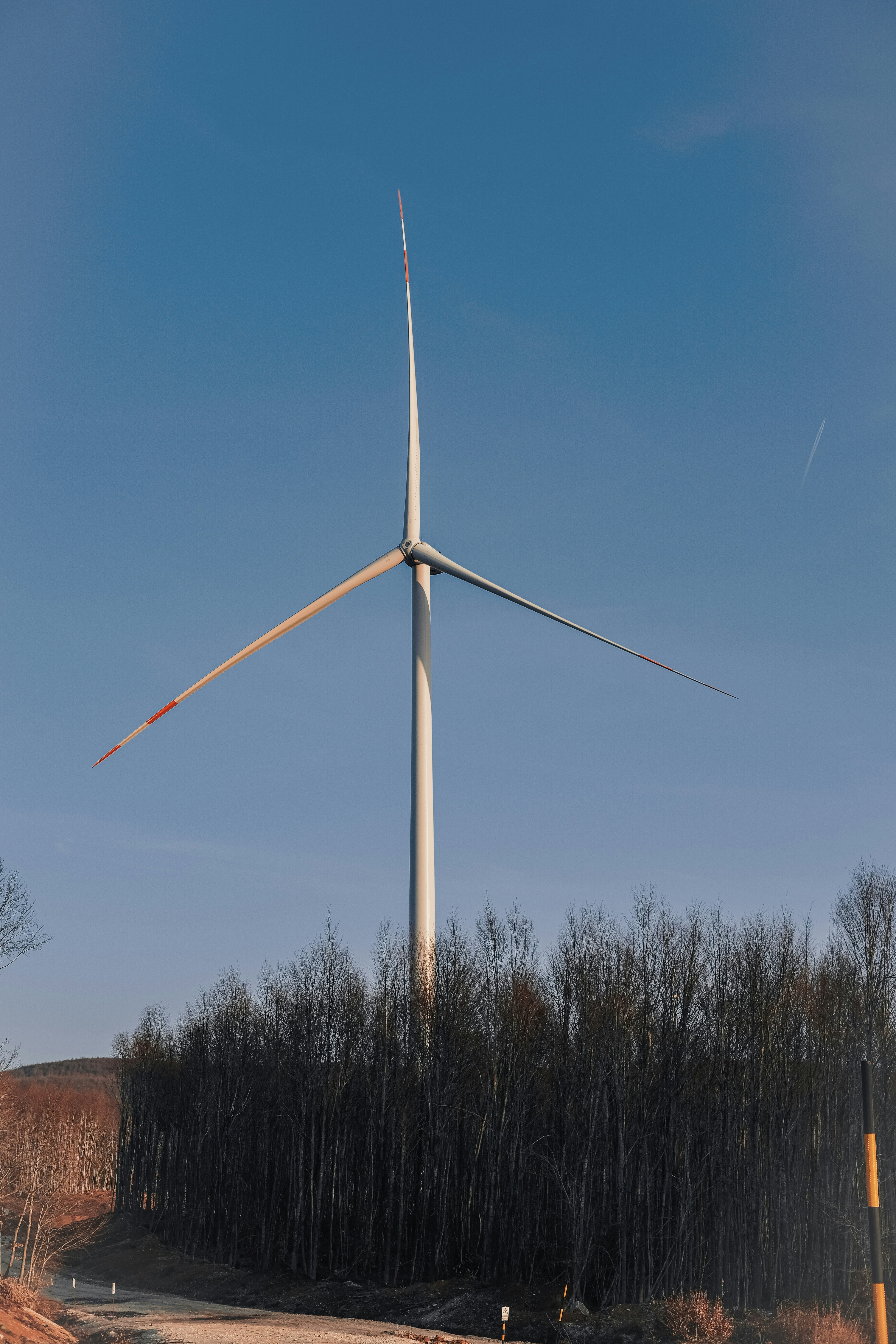 a wind turbine on the side of a dirt road