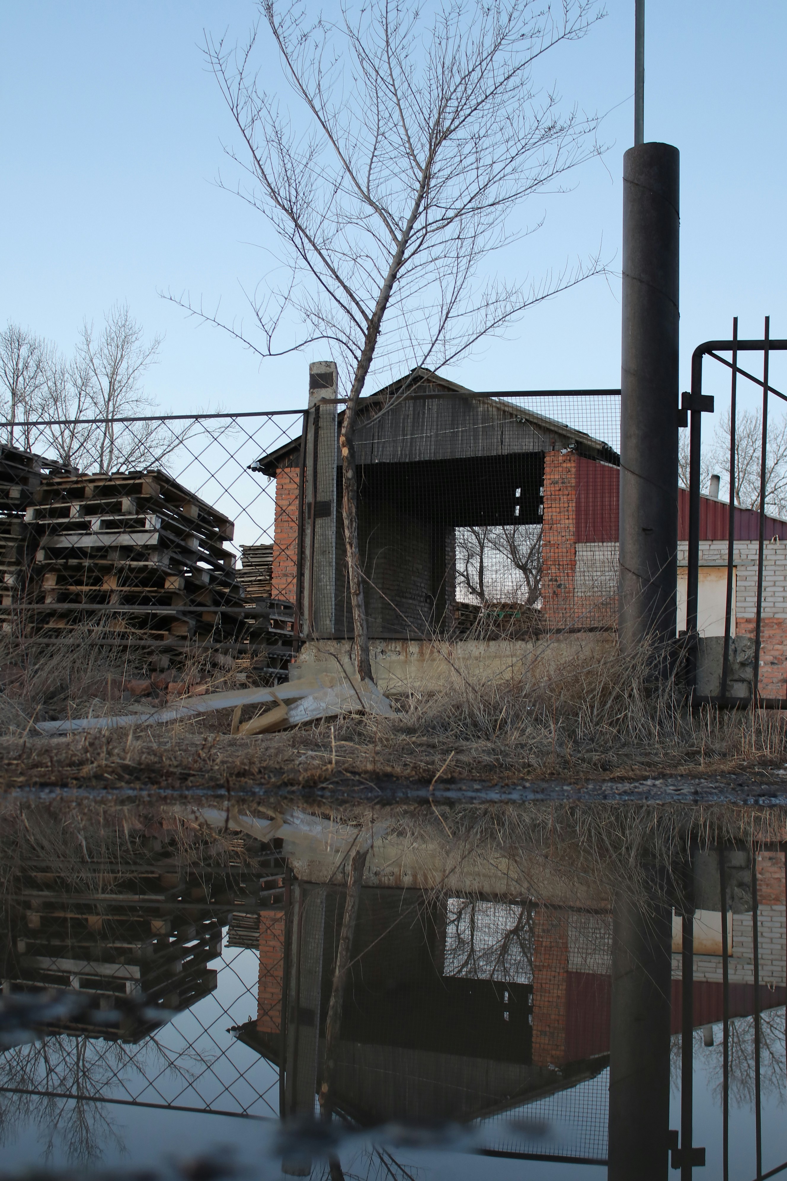 a building with a fence around it next to a body of water