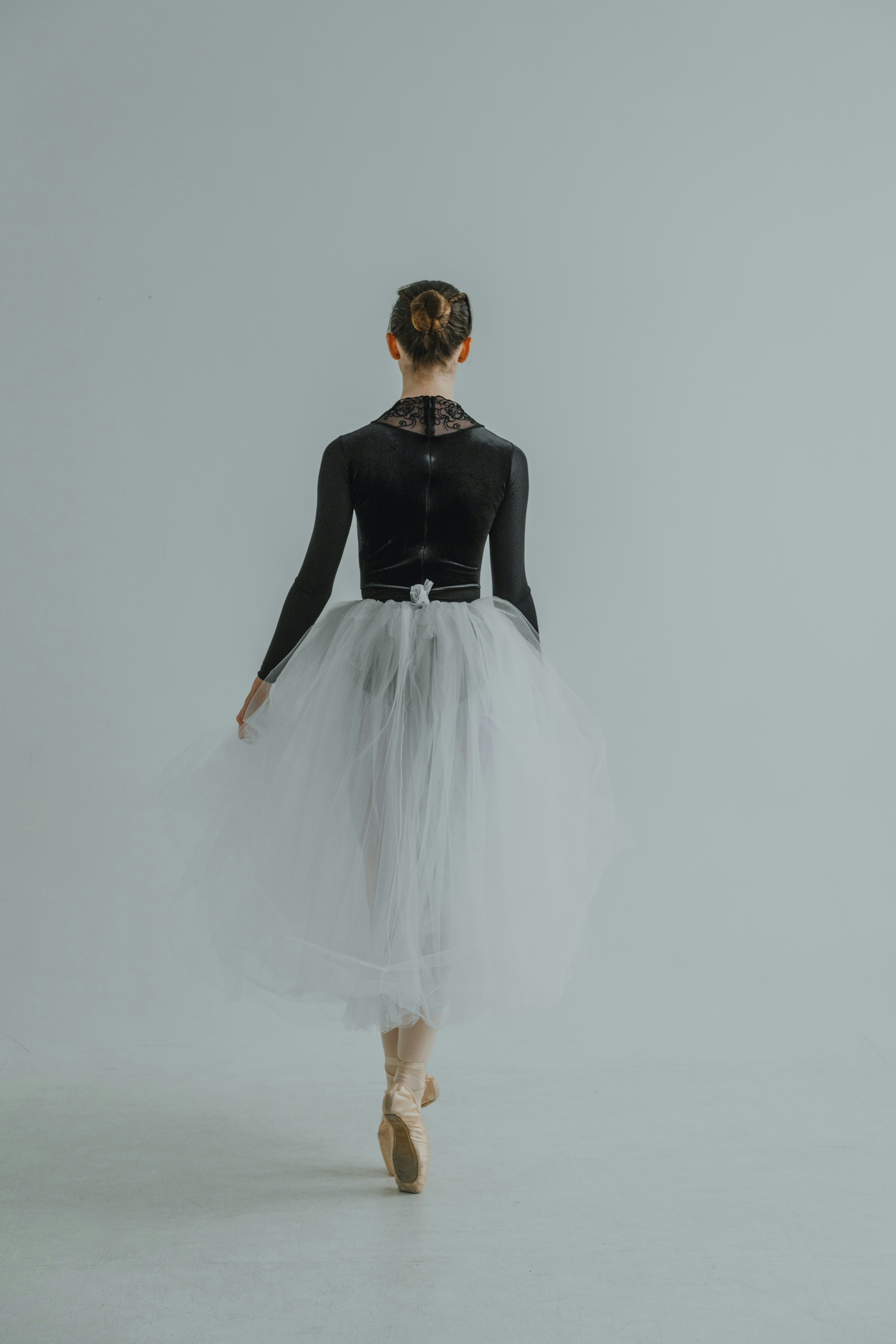 a woman in a black top and white tulle skirt