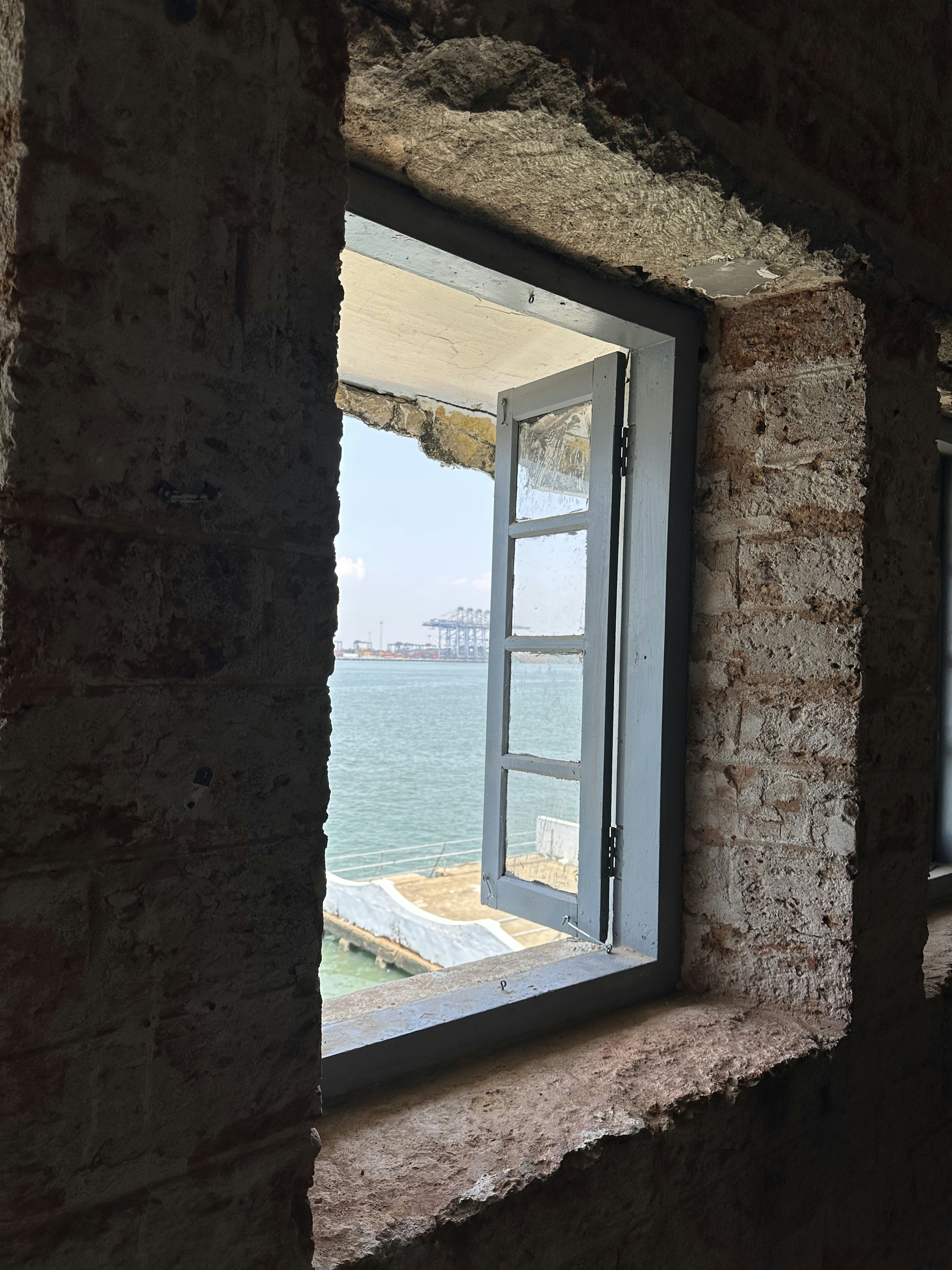Harbor Through a Crumbling Brick Window