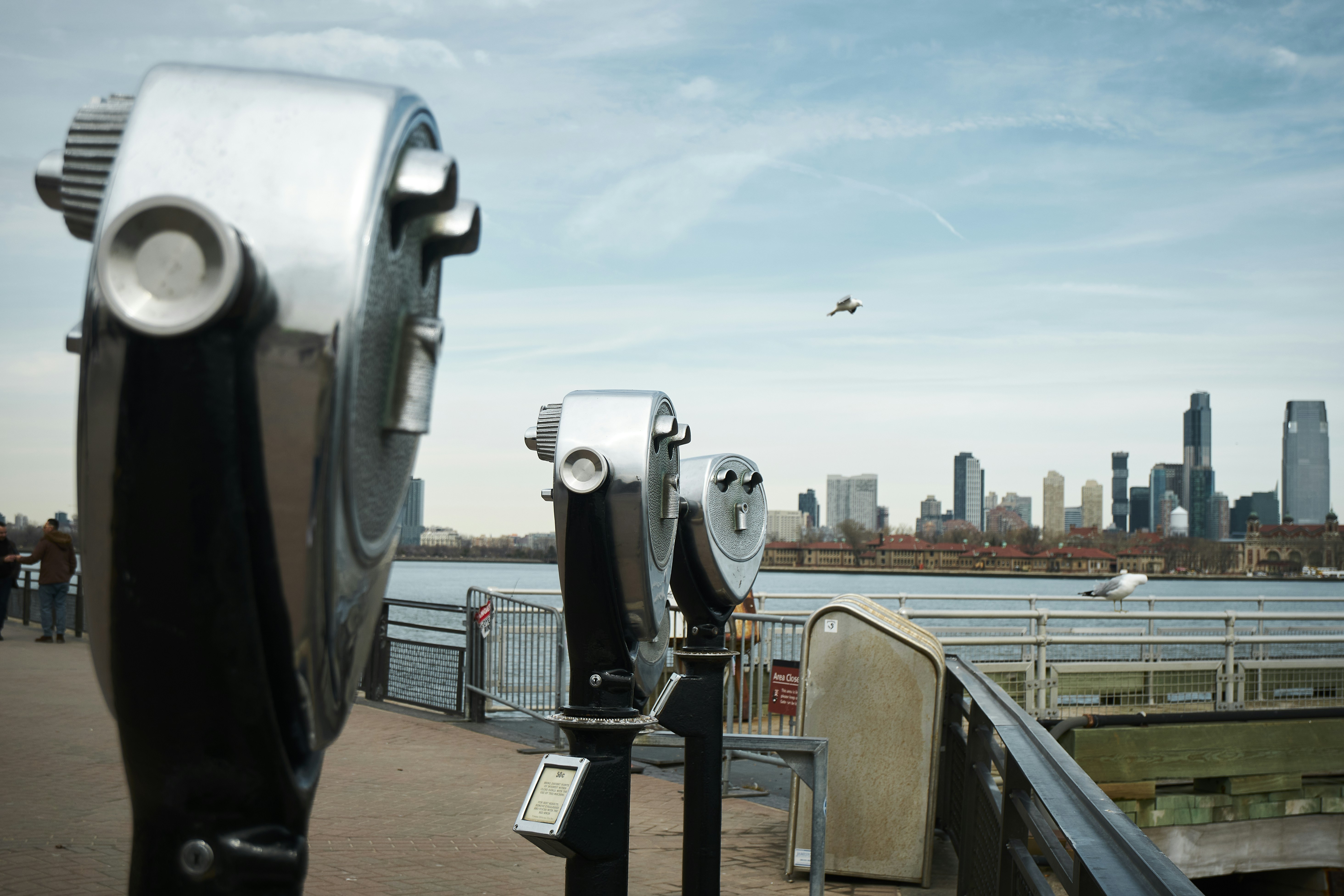 Coin-operated Vistas: Cityscape and Distant Skyline Framed by Public Muted Dusk Lights