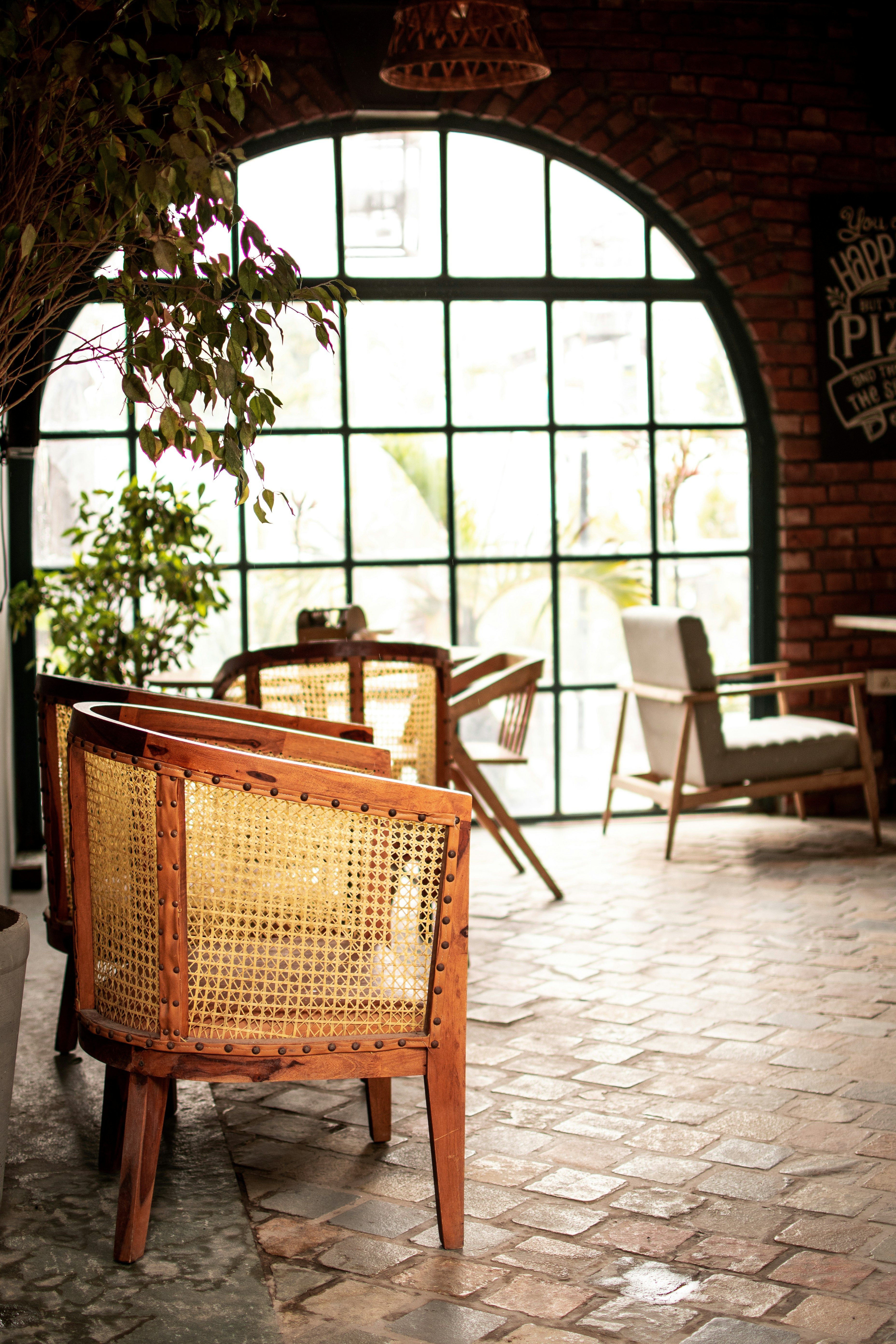 Sunlit Cane-Backed Chair Anchors a Quiet Brick-Walled Café