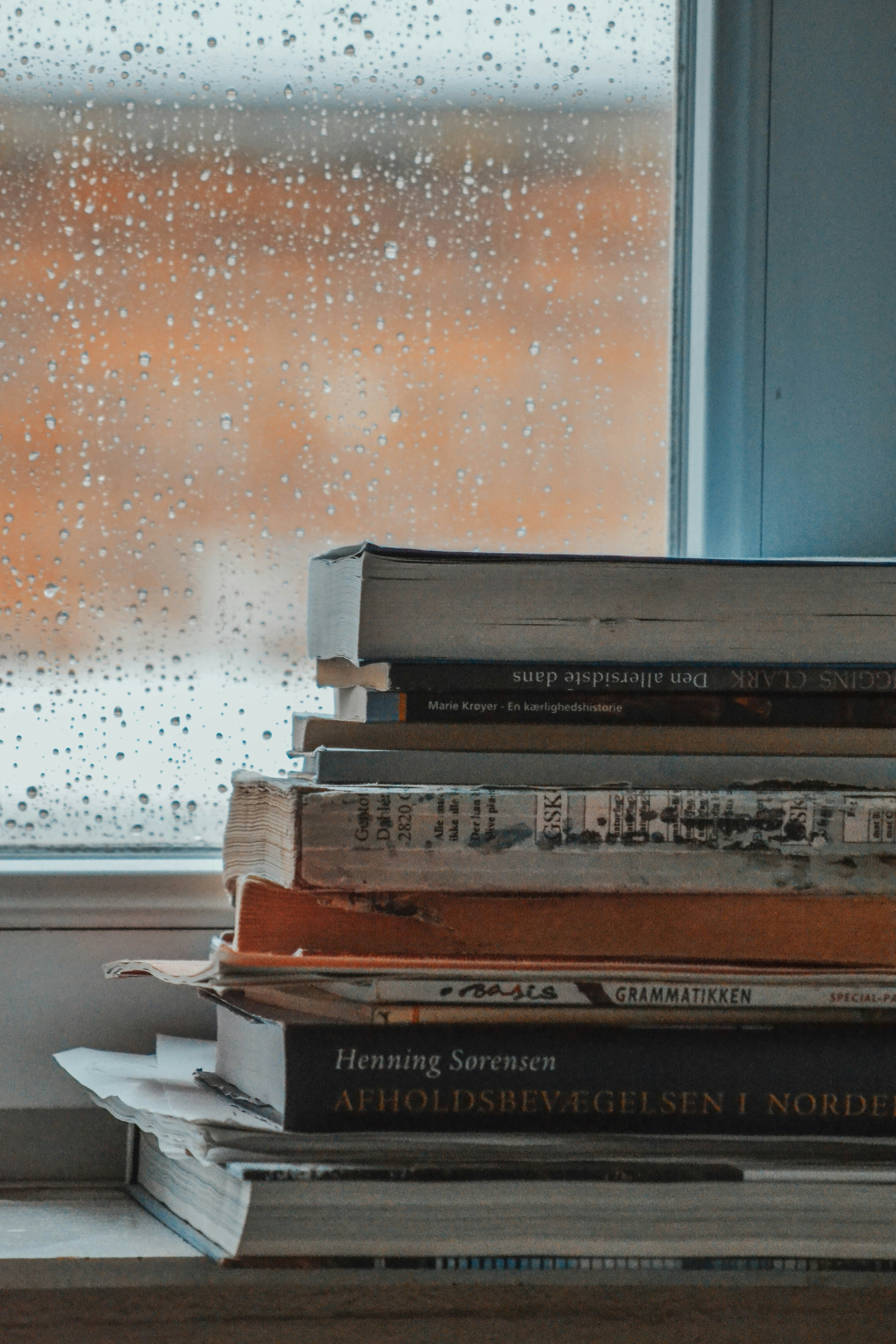 A stack of books sitting on top of a window sill photo – Free Book ...