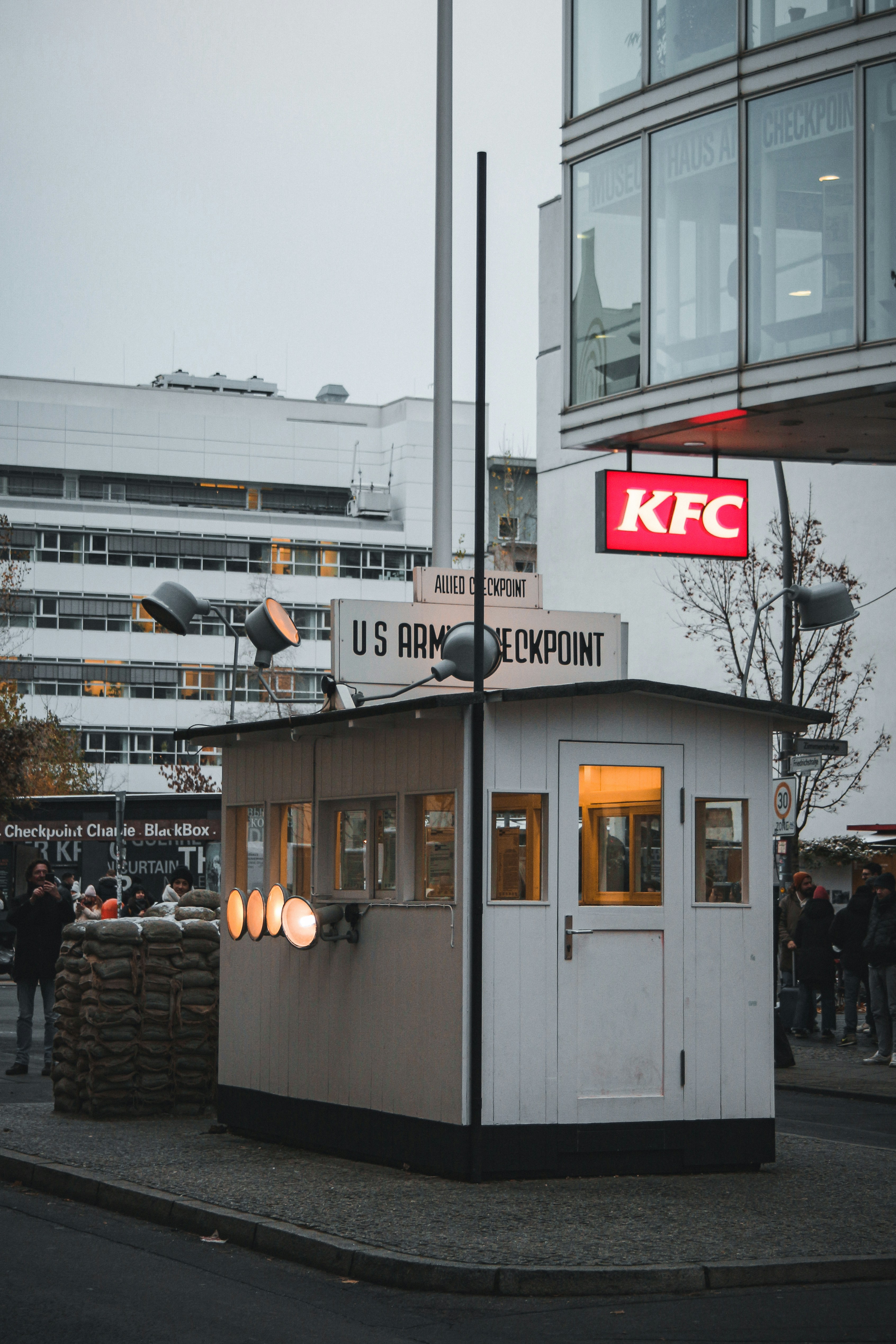 KFC Sign Looms Over a Makeshift Checkpoint Booth in an Urban Square