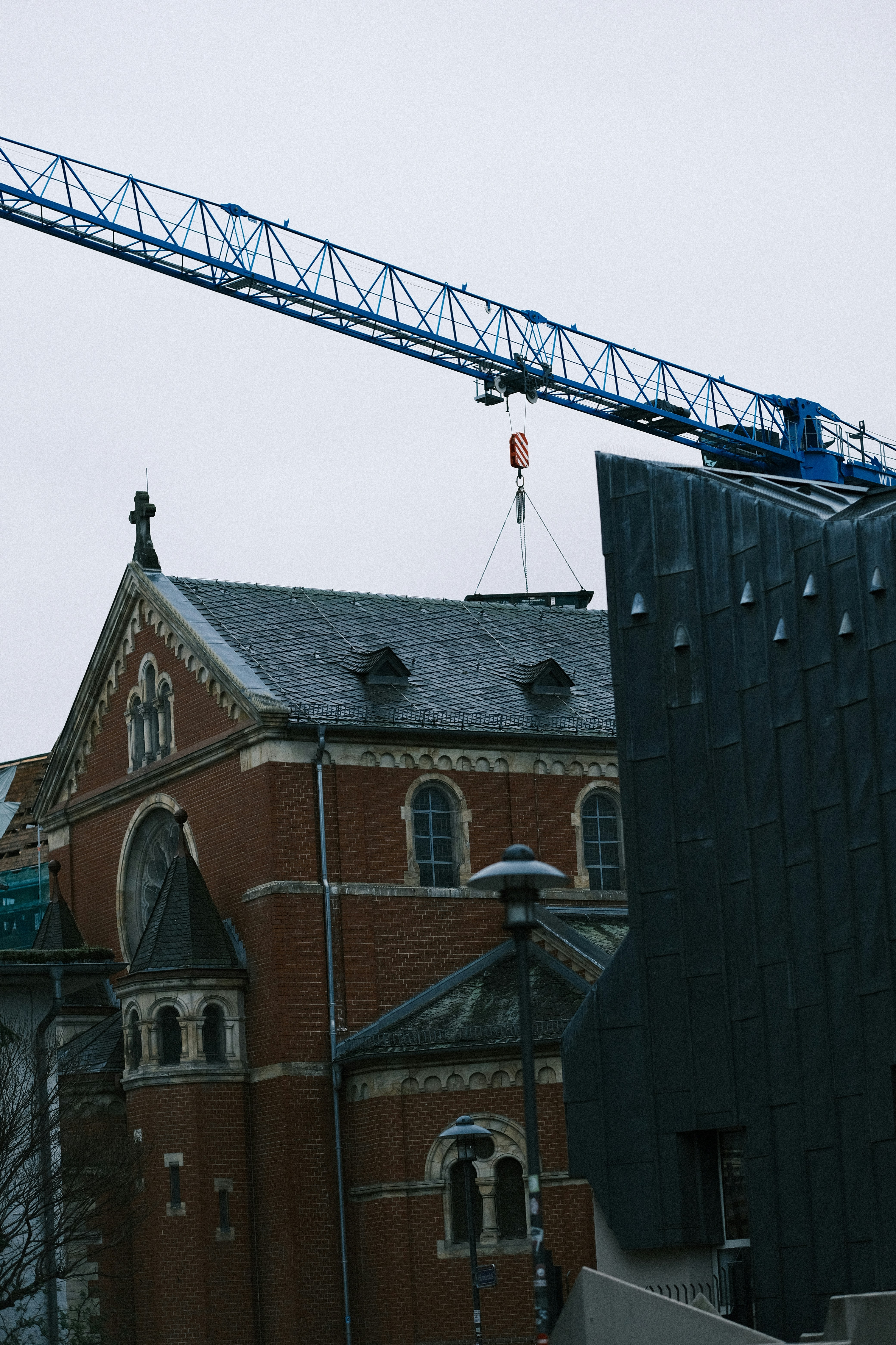 Crane Crossing a Red Brick Church Under Construction