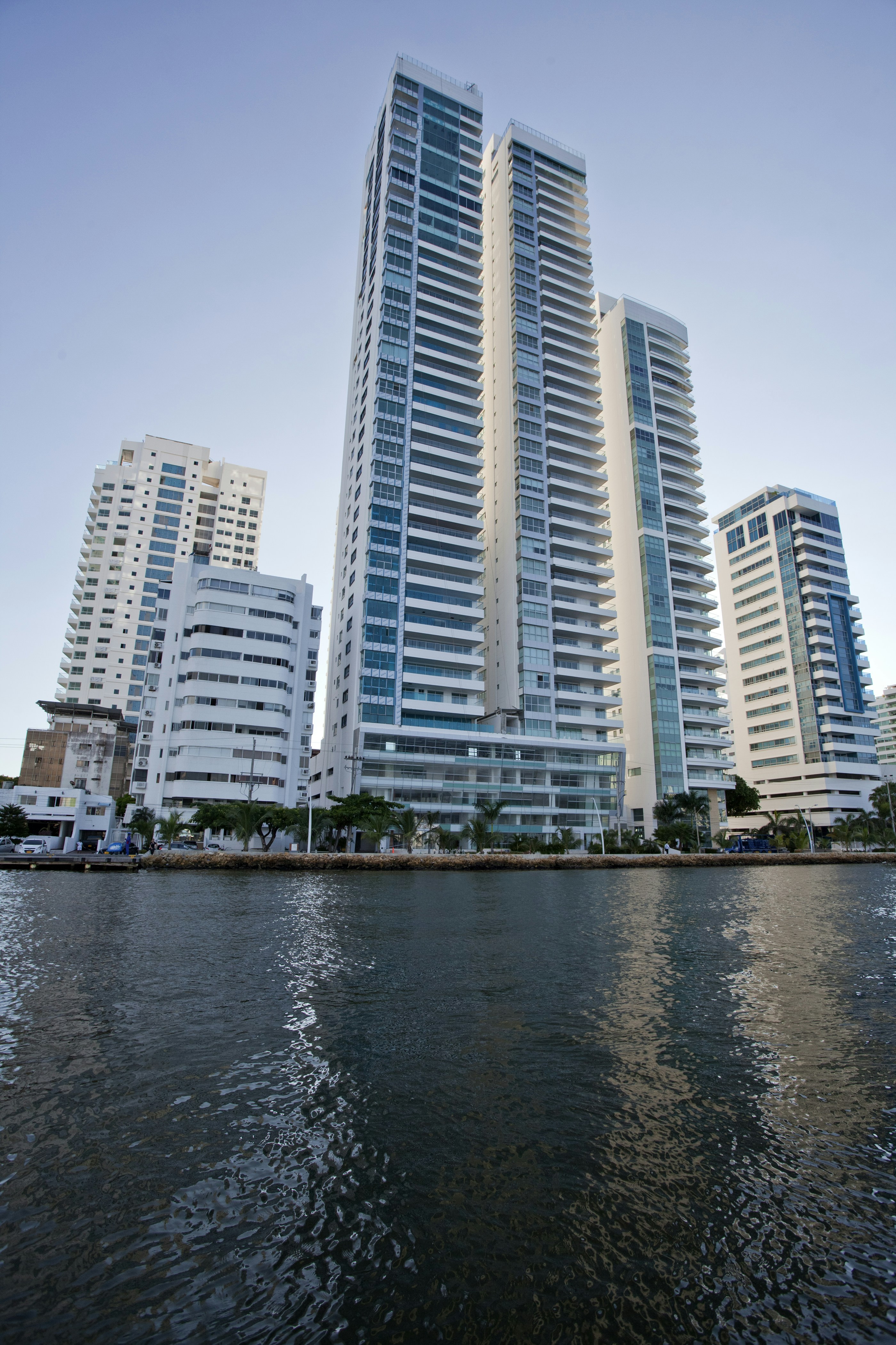 Modern high-rise buildings in Bocagrande district reflecting on calm waters at dusk.