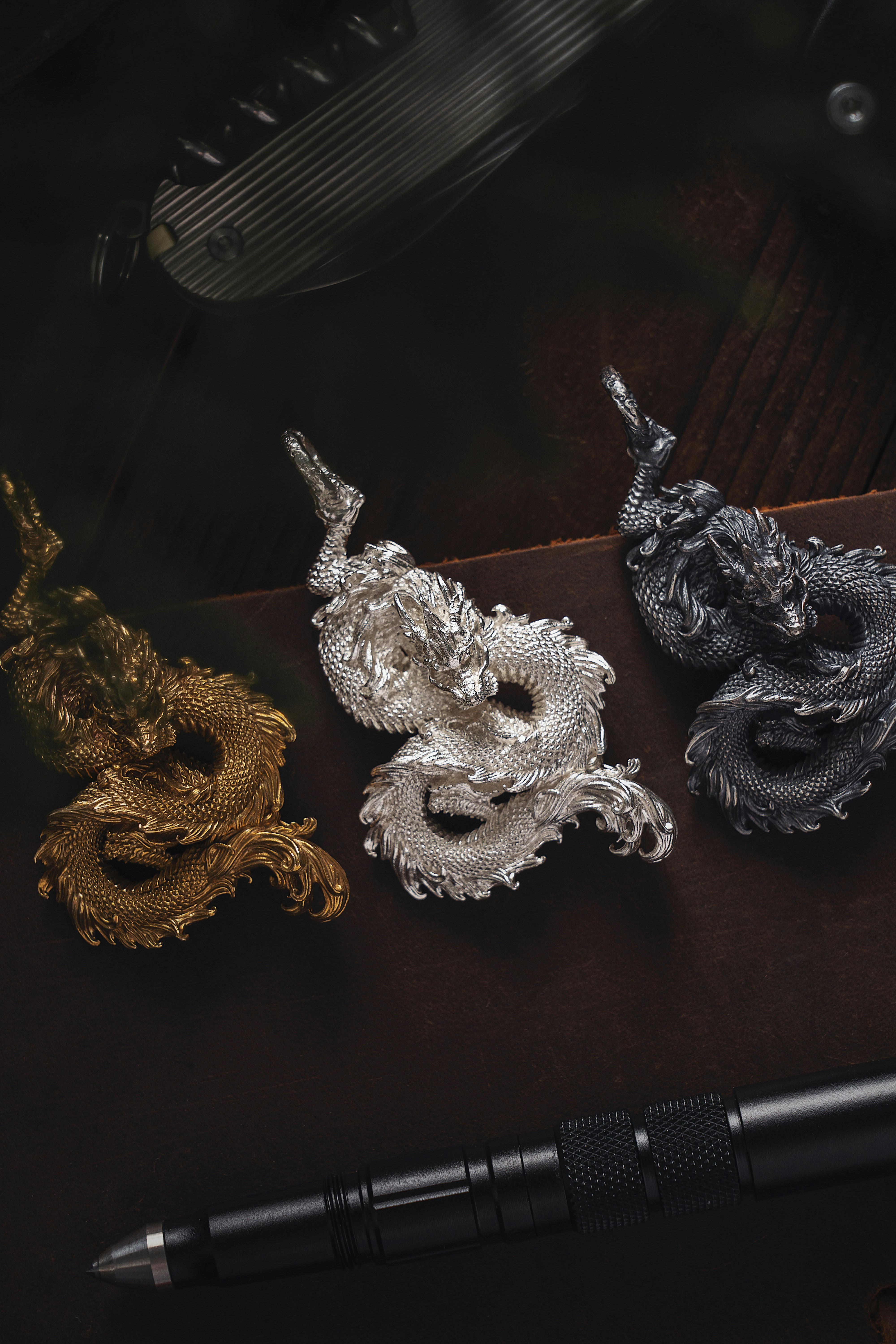 Trio of Metallic Dragons on a Shadowed Workbench