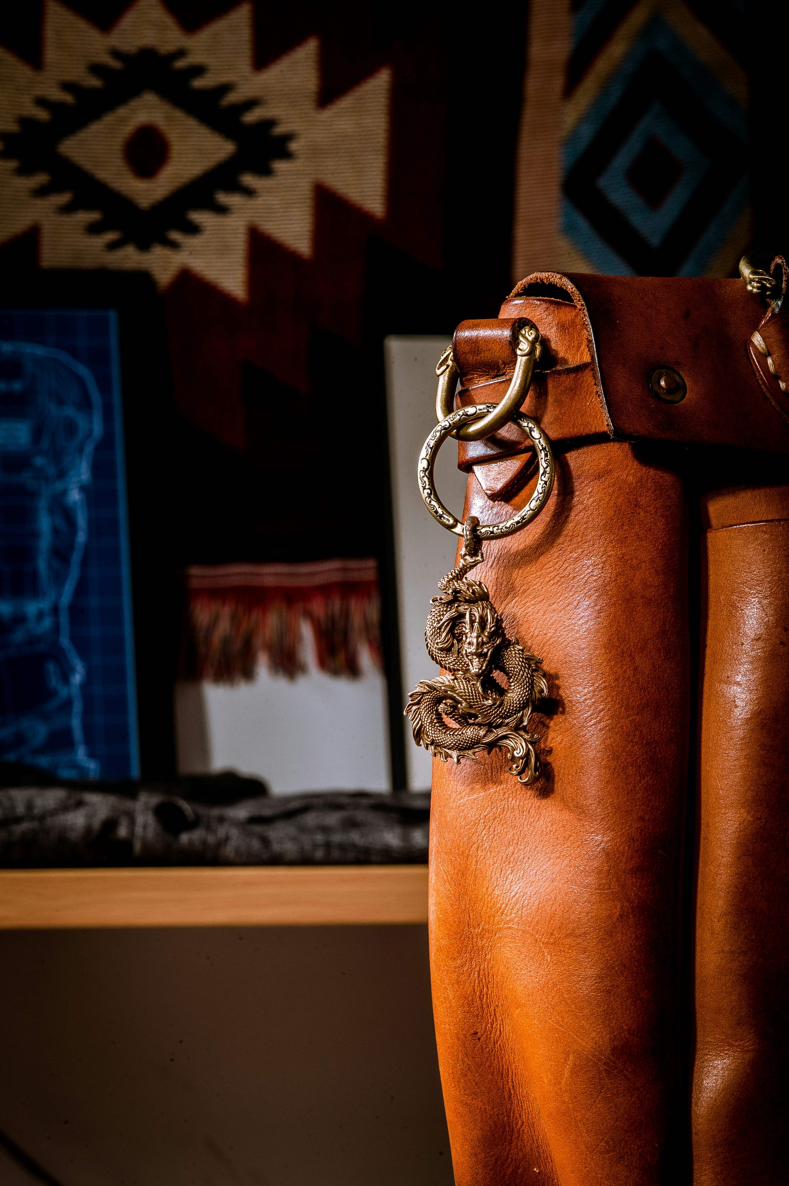 Close-Up of a Leather Satchel: Ring, Knot, and a Geometric Textile Backdrop
