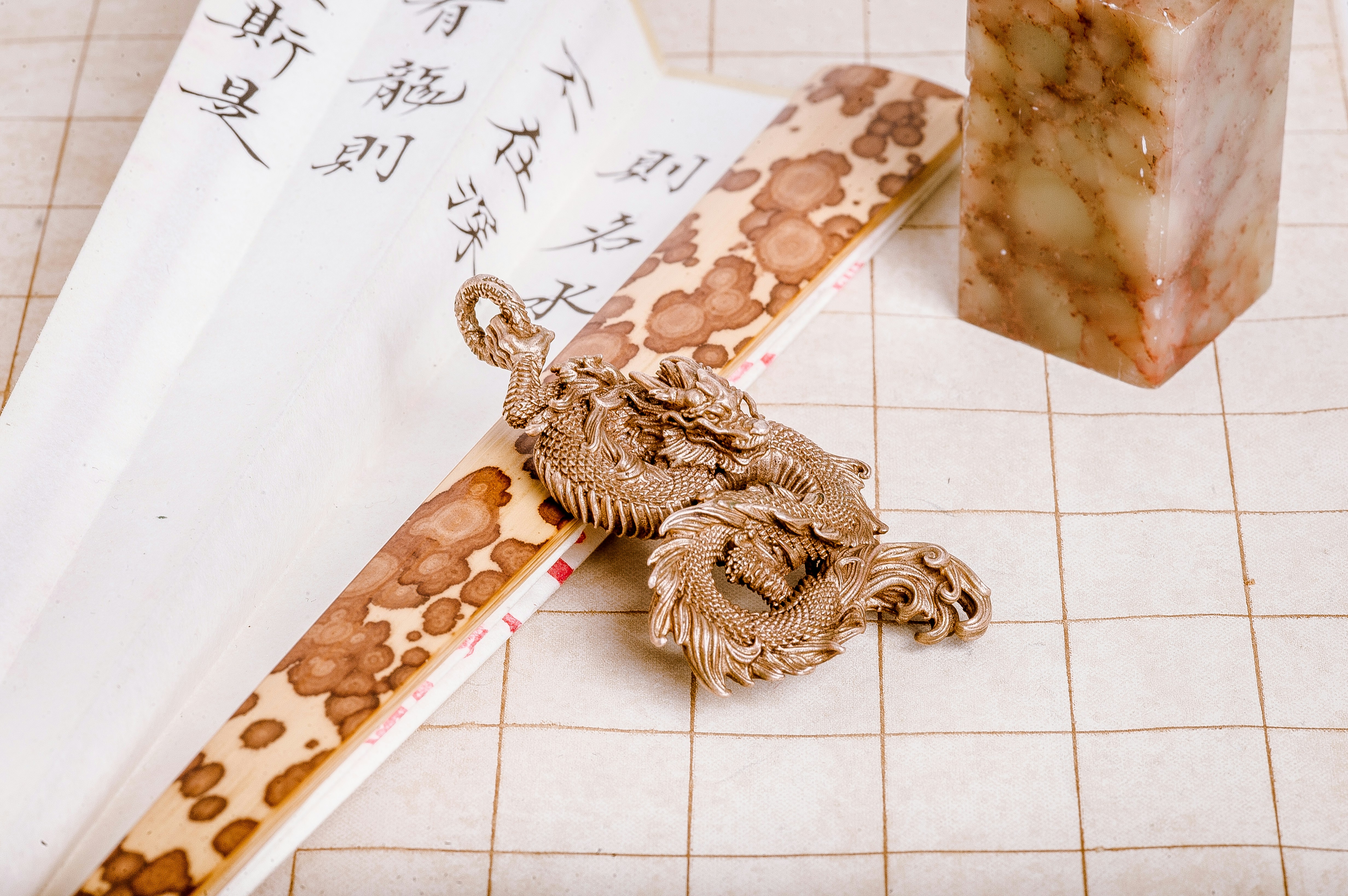 Dragon Filigree Talisman Resting on Calligraphy Strip with Marble Block