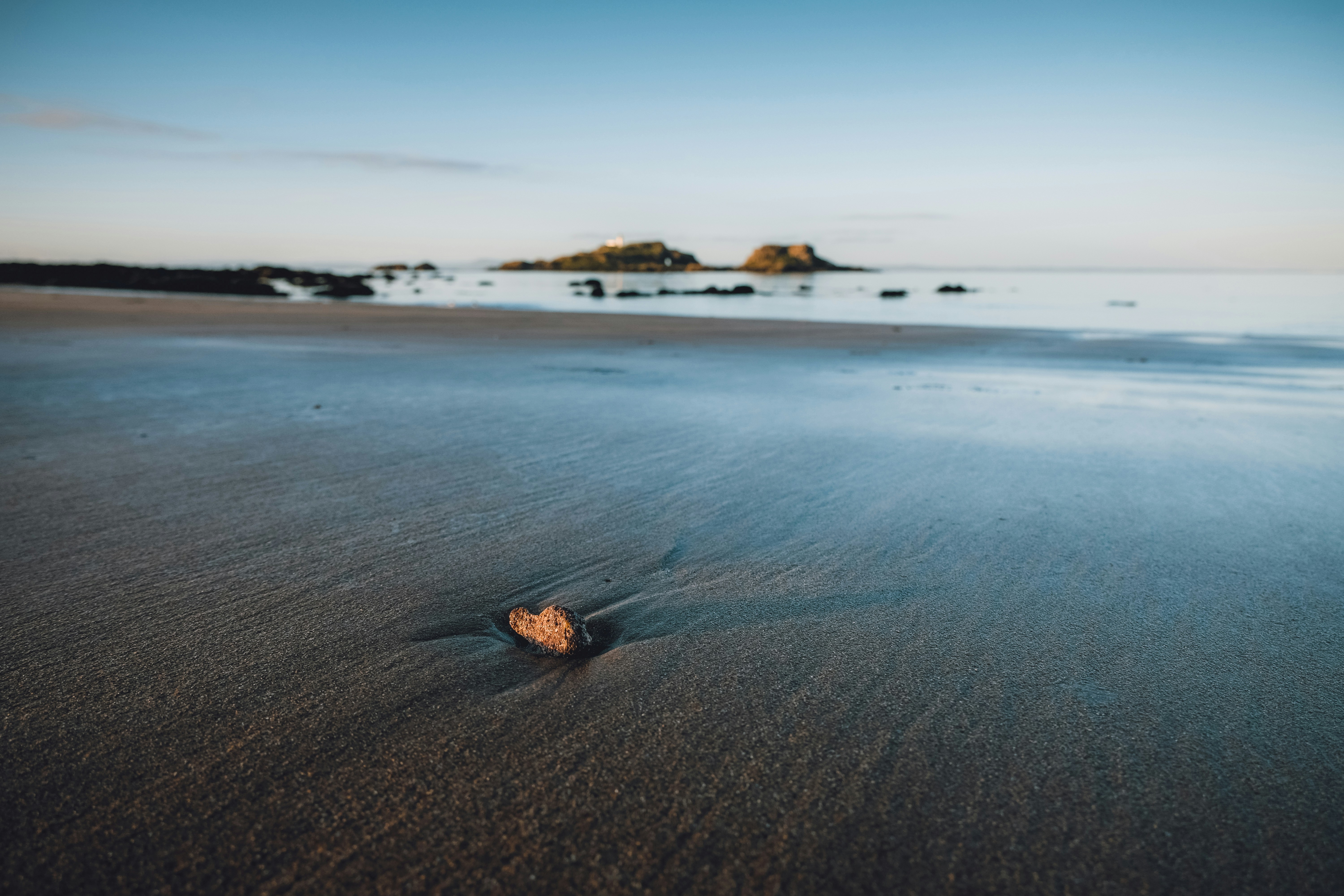 A rock in the sand on a beach photo – Free Yellowcraig beach Image on ...