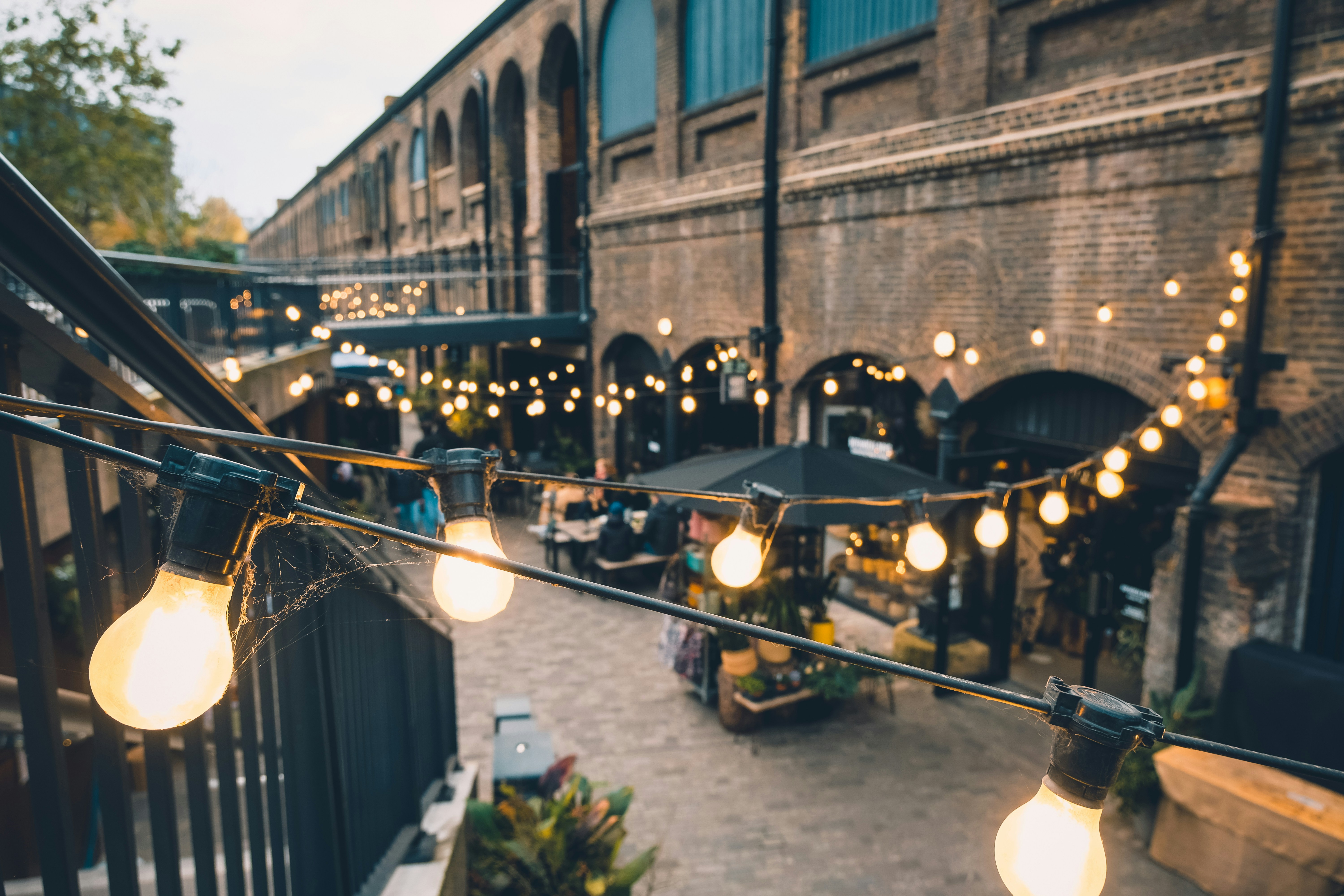 Twinkling Dinner Courtyard Under Hanging Bulbs