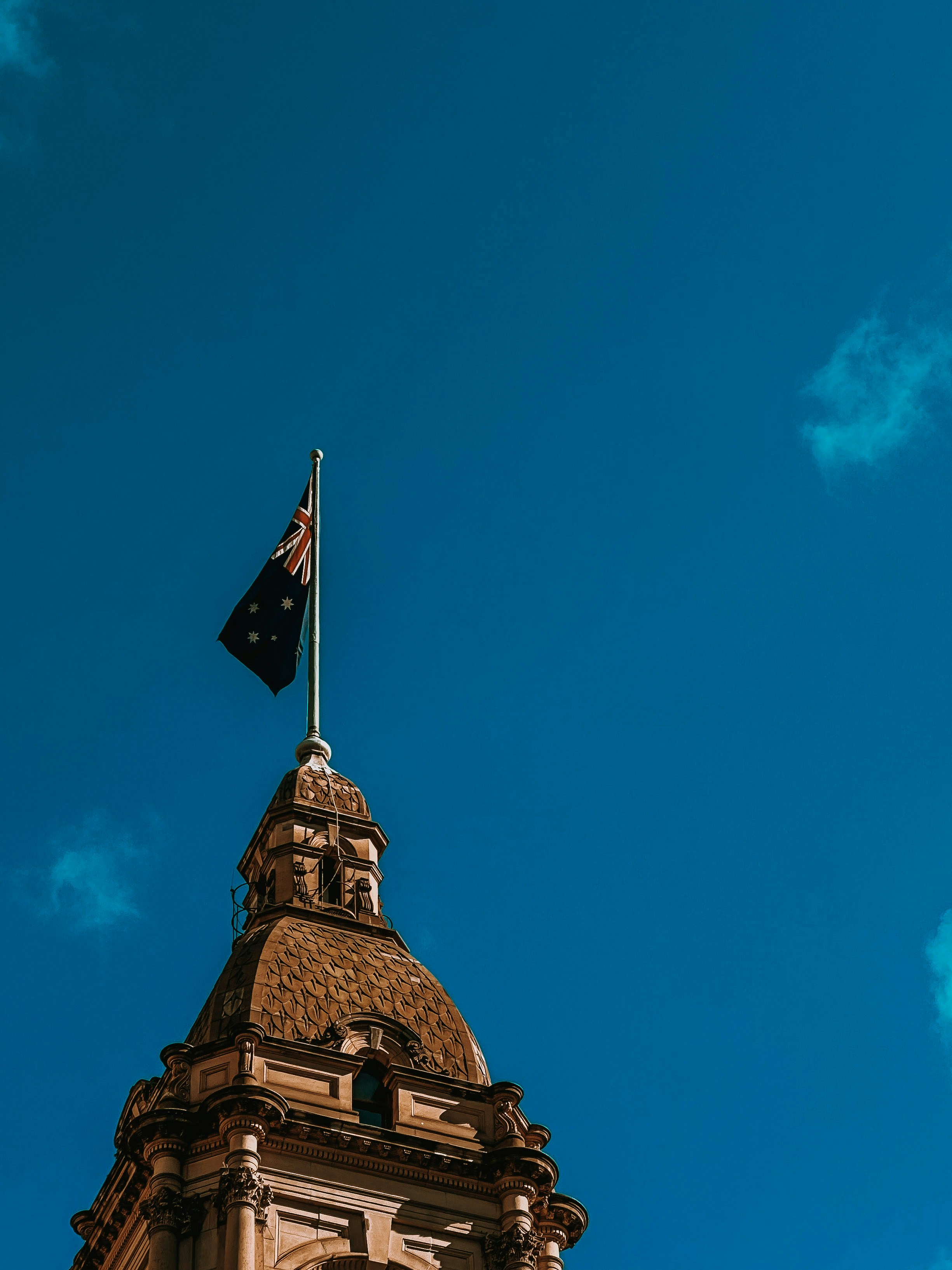 A tall building with a flag on top of it photo – Free Flag Image on ...