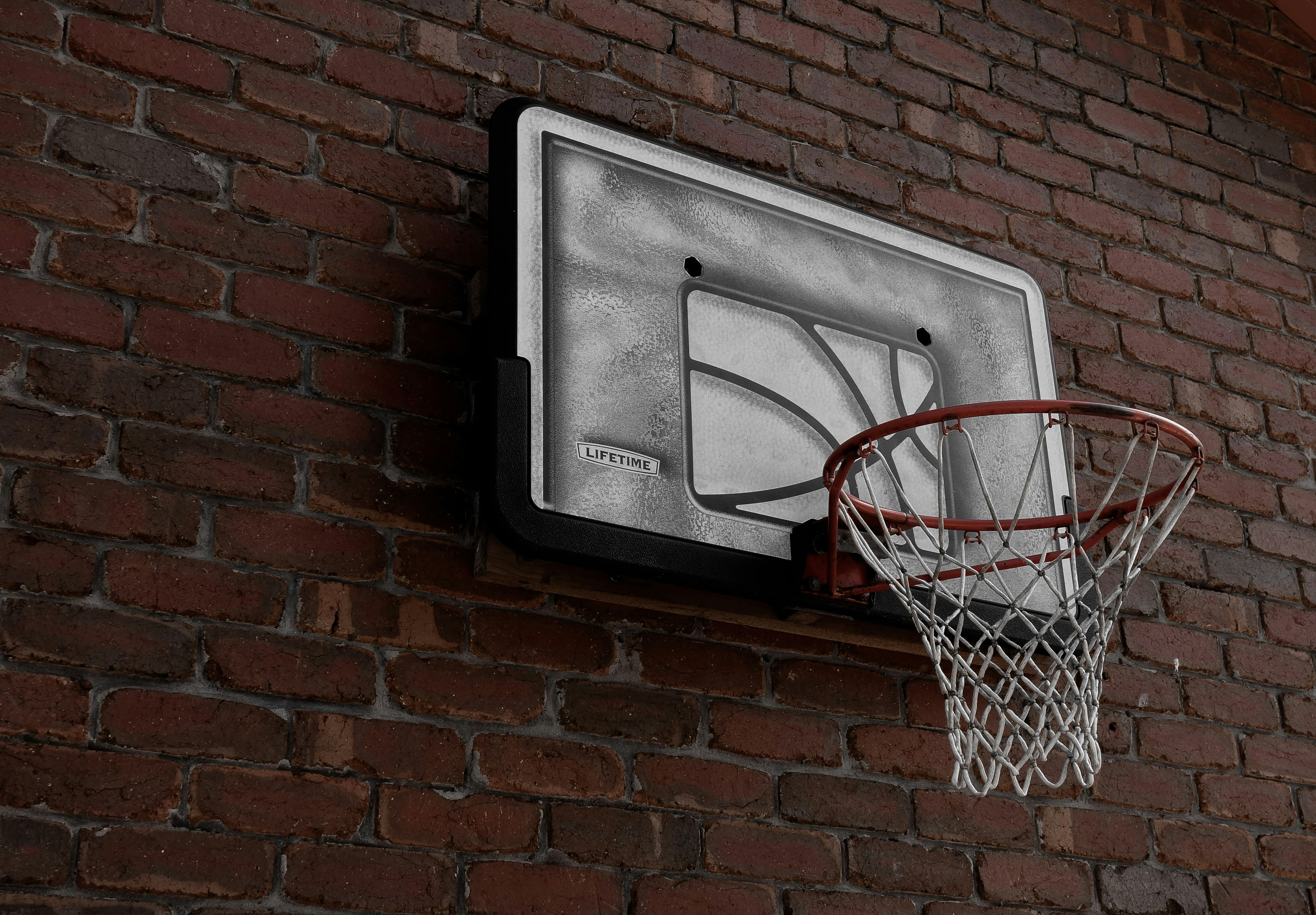 A basketball hoop mounted to a brick wall photo – Free Hoop Image on ...