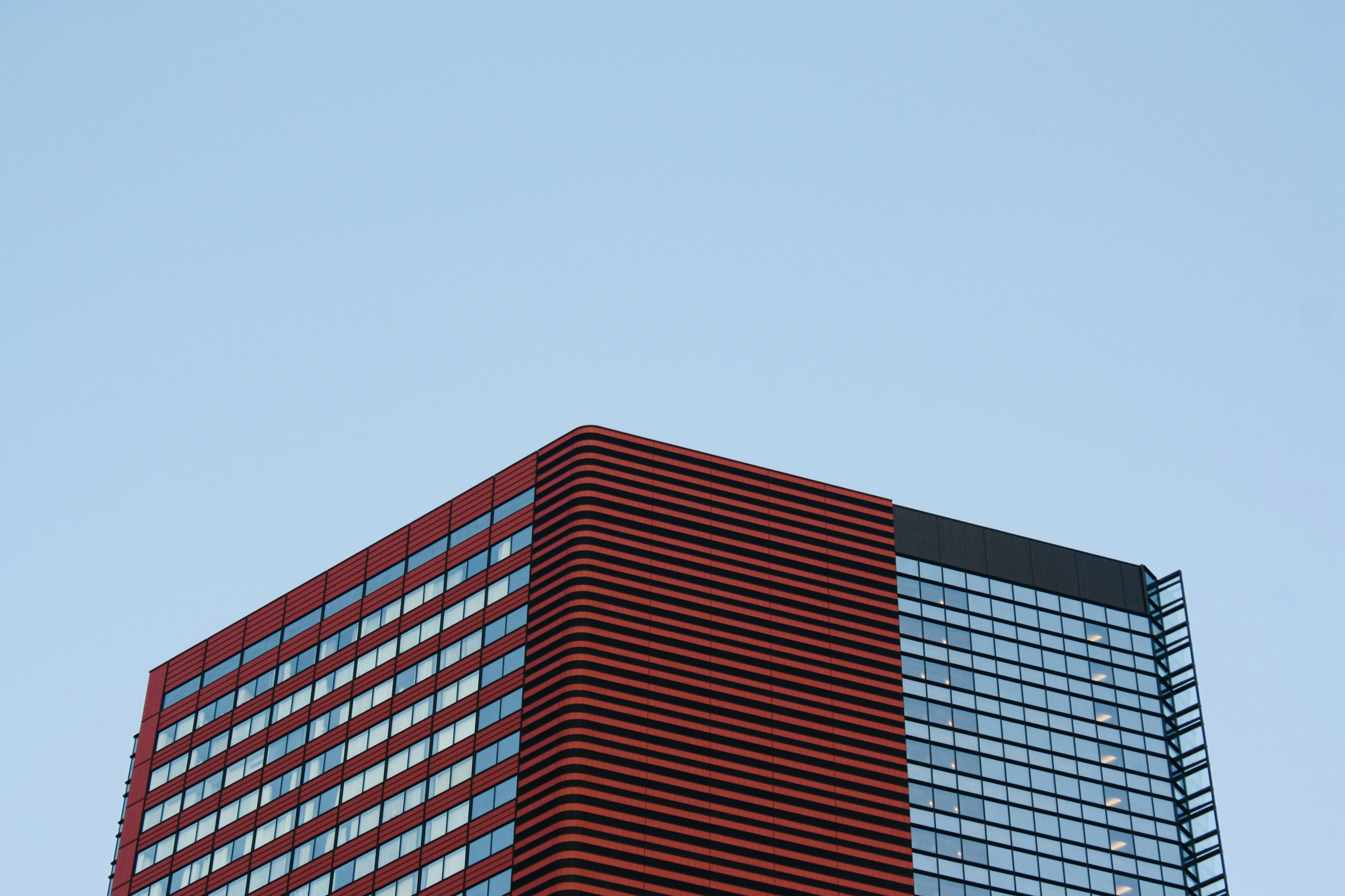 A very tall red and black building with a sky background photo – Free ...