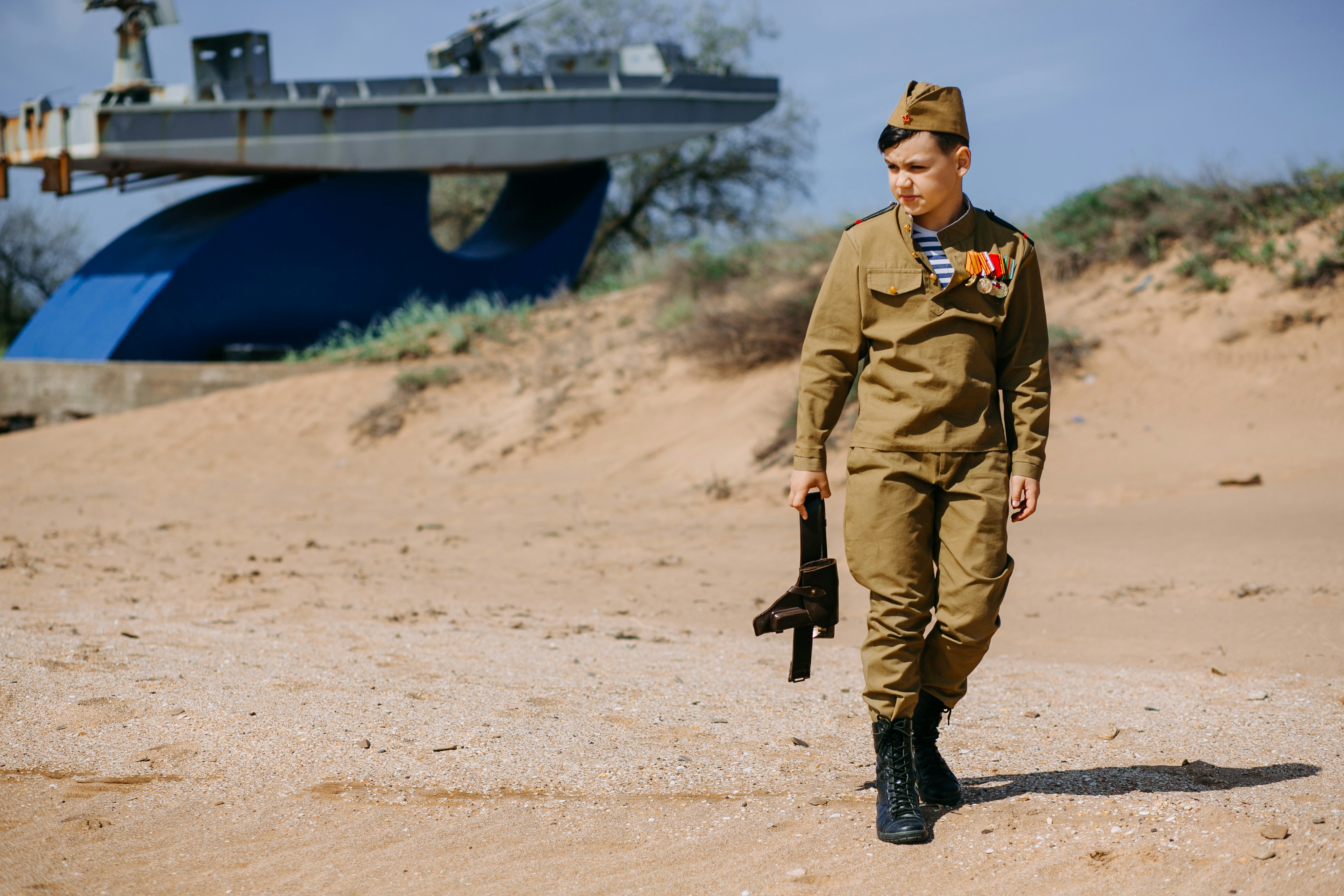 A man in a military uniform walking on a beach photo – Free Man Image ...