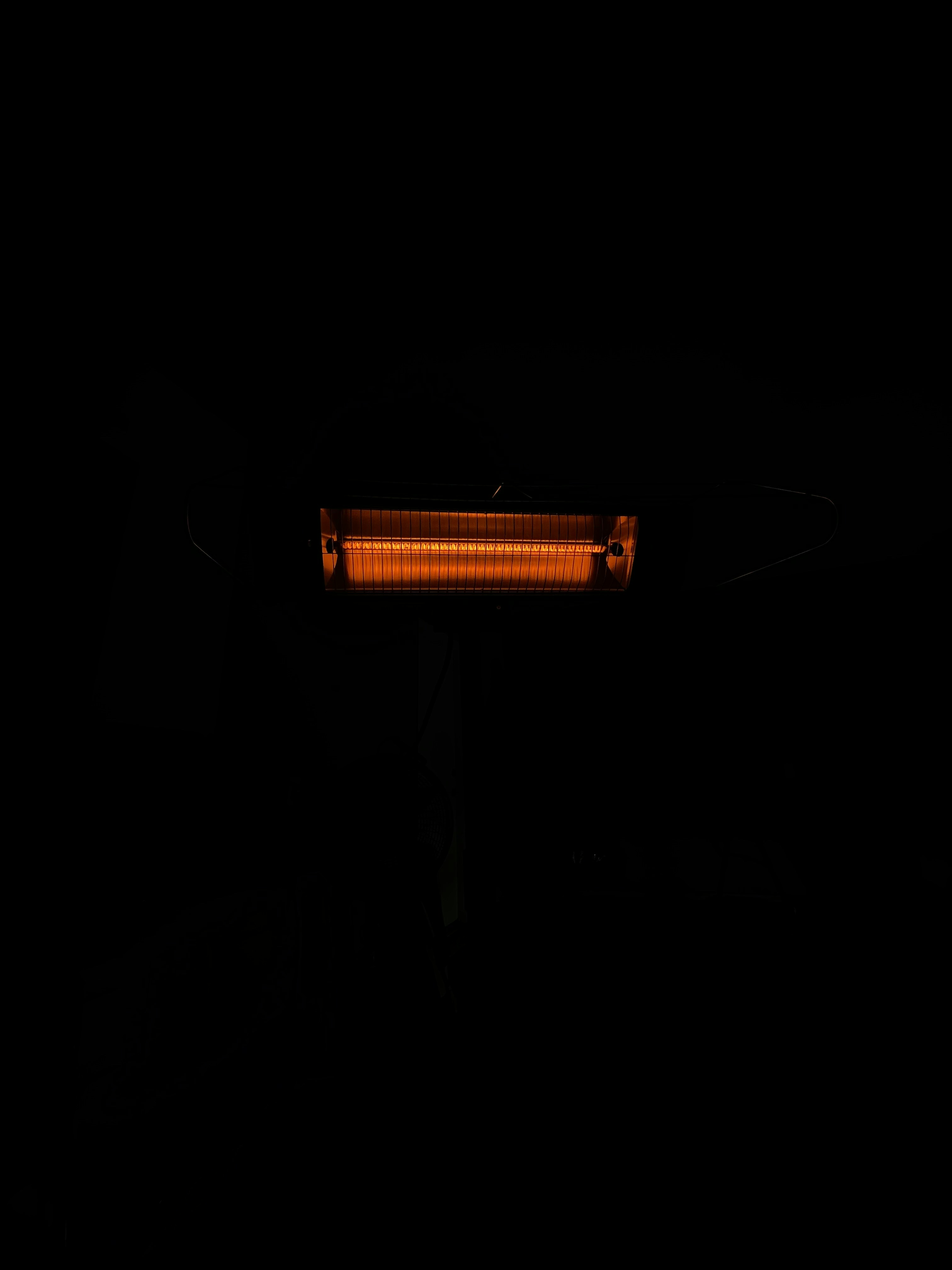 A glowing orange heater element against a dark backdrop, highlighting its radiant warmth and design.