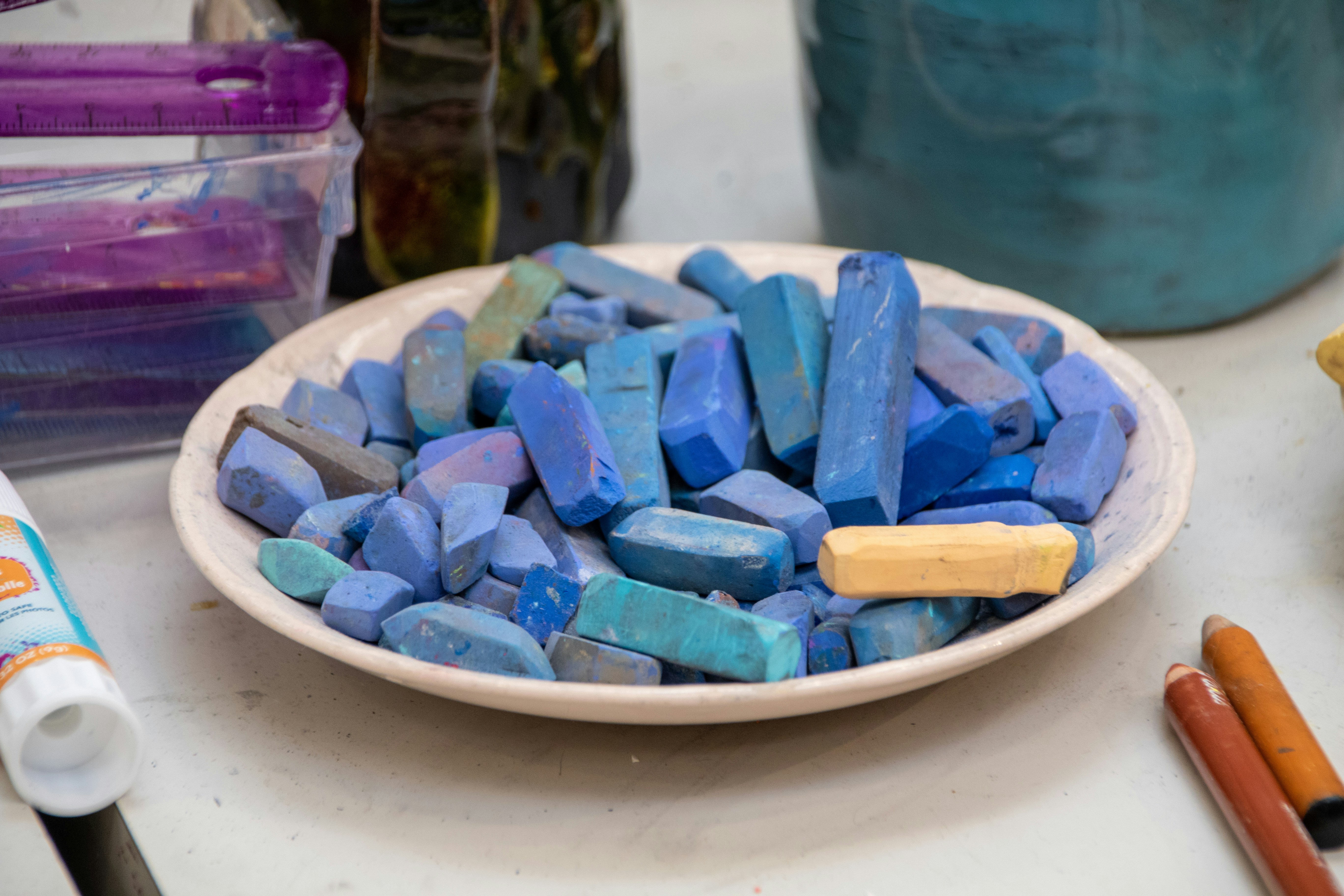 A Palette of Quiet Blues: Chalk Fragments Arranged on a White Plate