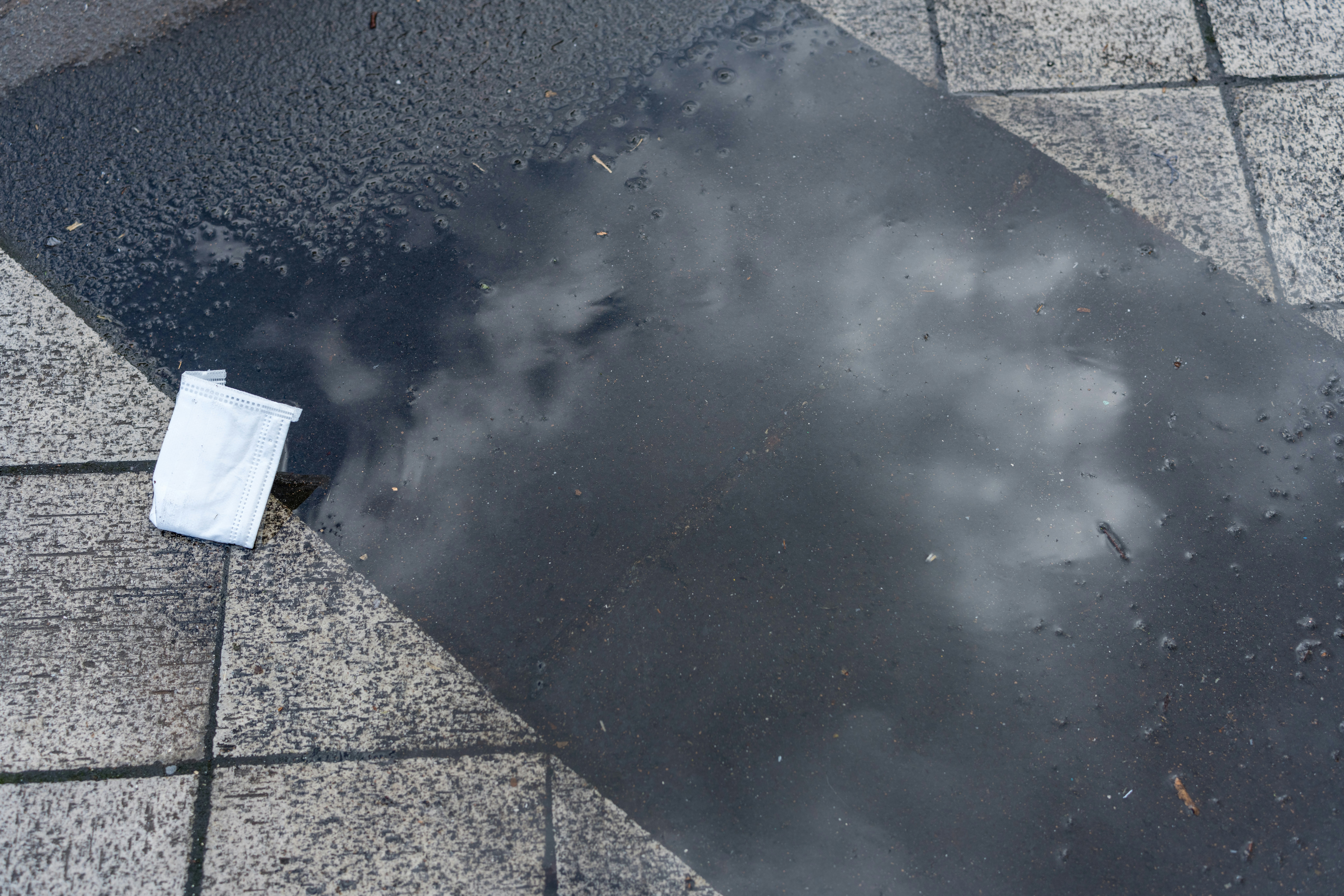 a puddle of water sitting on top of a sidewalk
