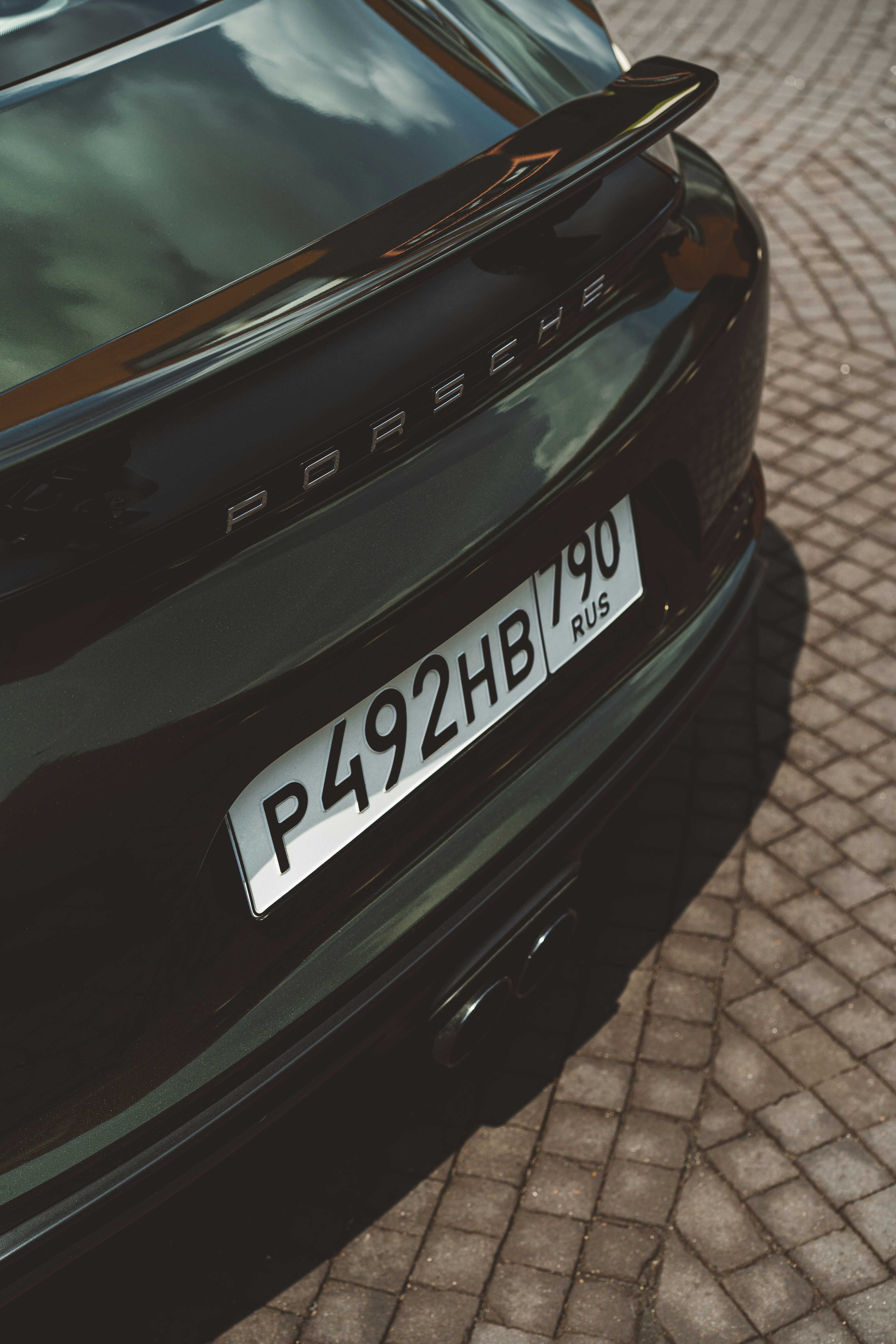 Green Porsche Badge and Russian Plate at a Curved Angle