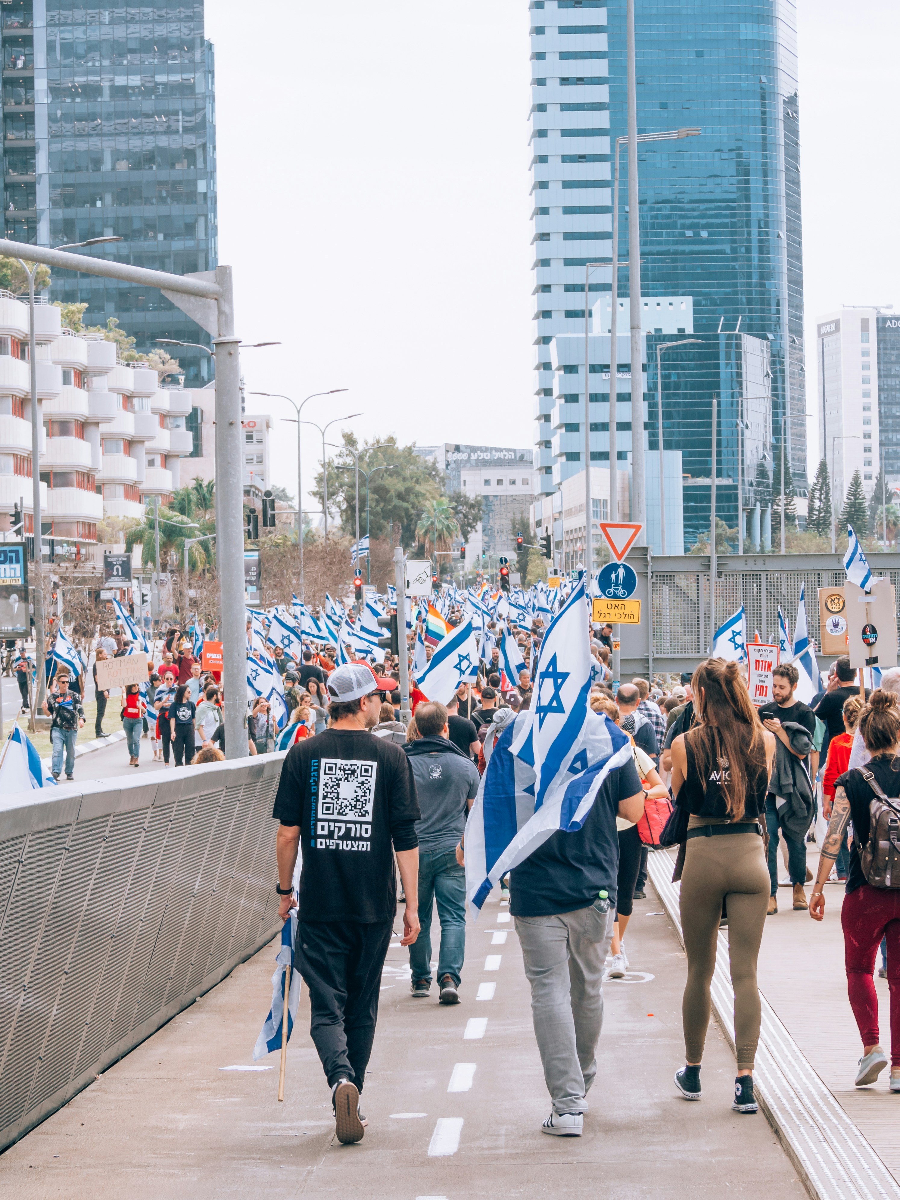 Marching Waves of Blue and Israel Flags Through an Urban Corridor