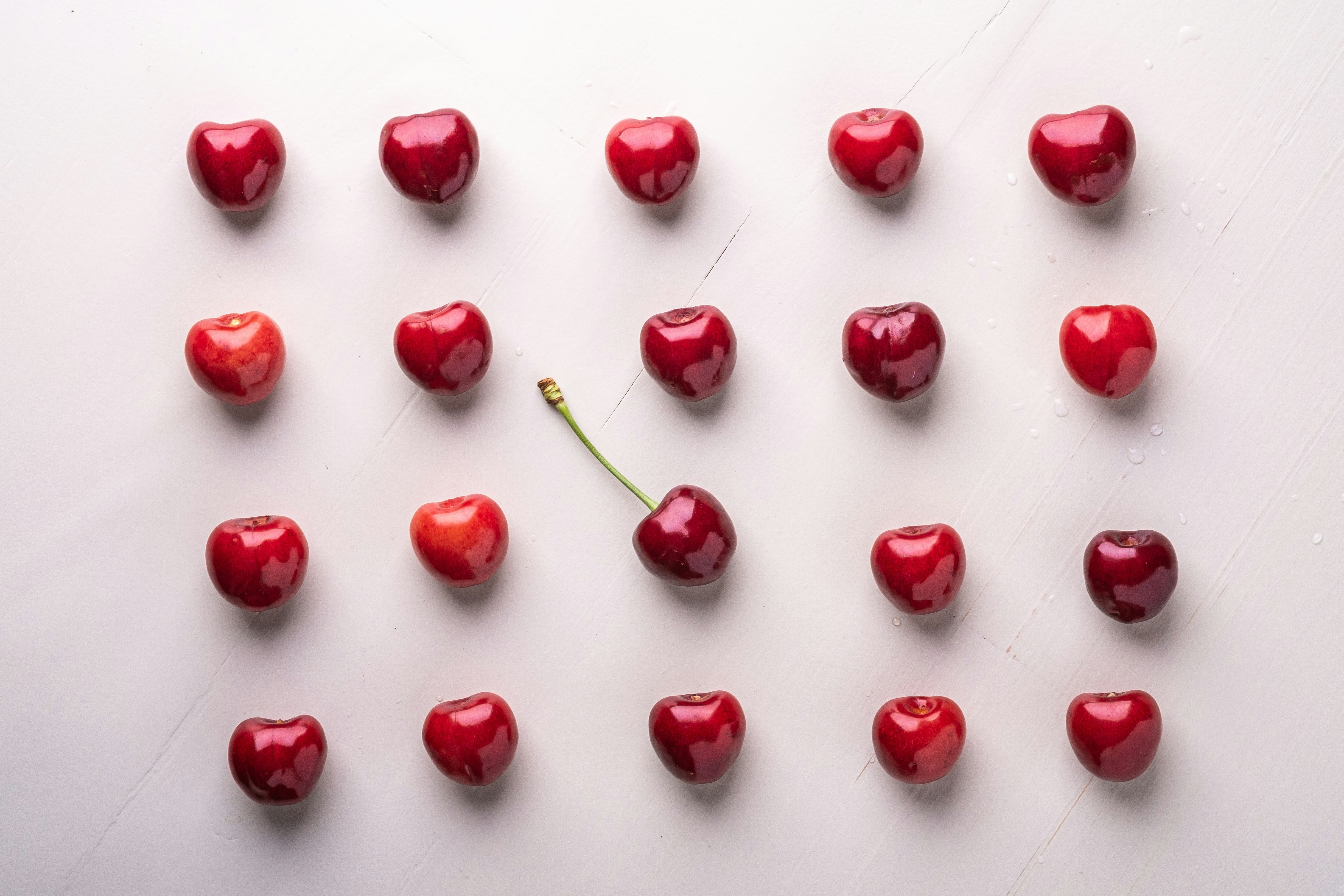 A group of red cherries on a white surface photo – Free Ukraine Image ...