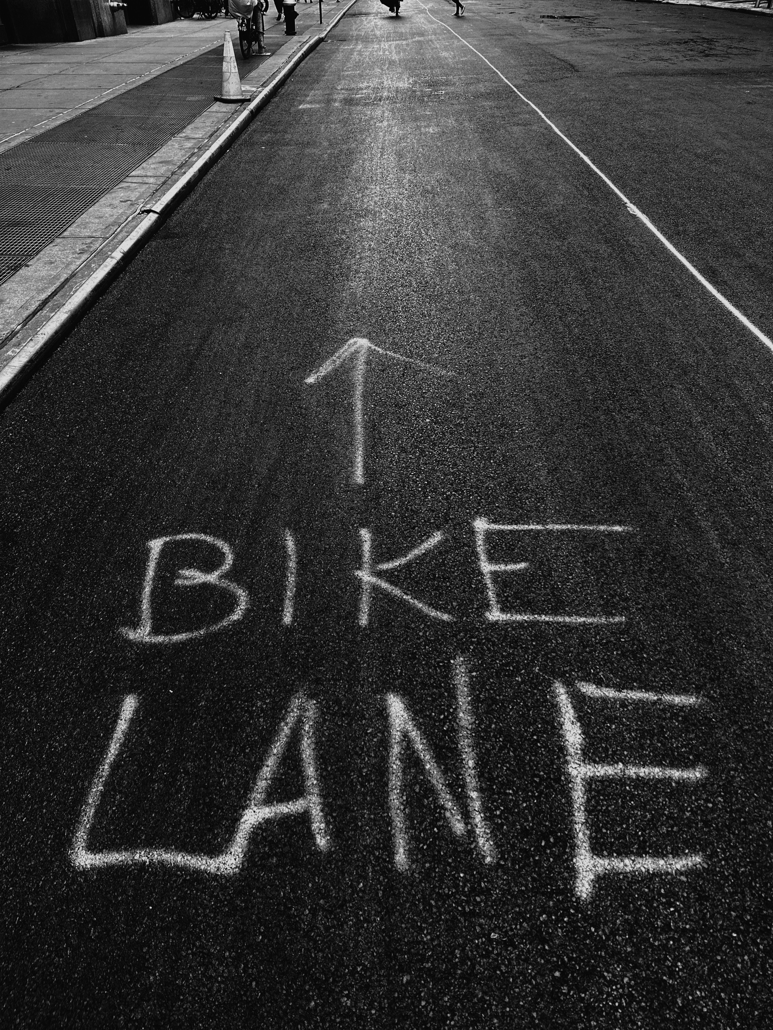 A black and white photo of a street with the words bike lane written in ...