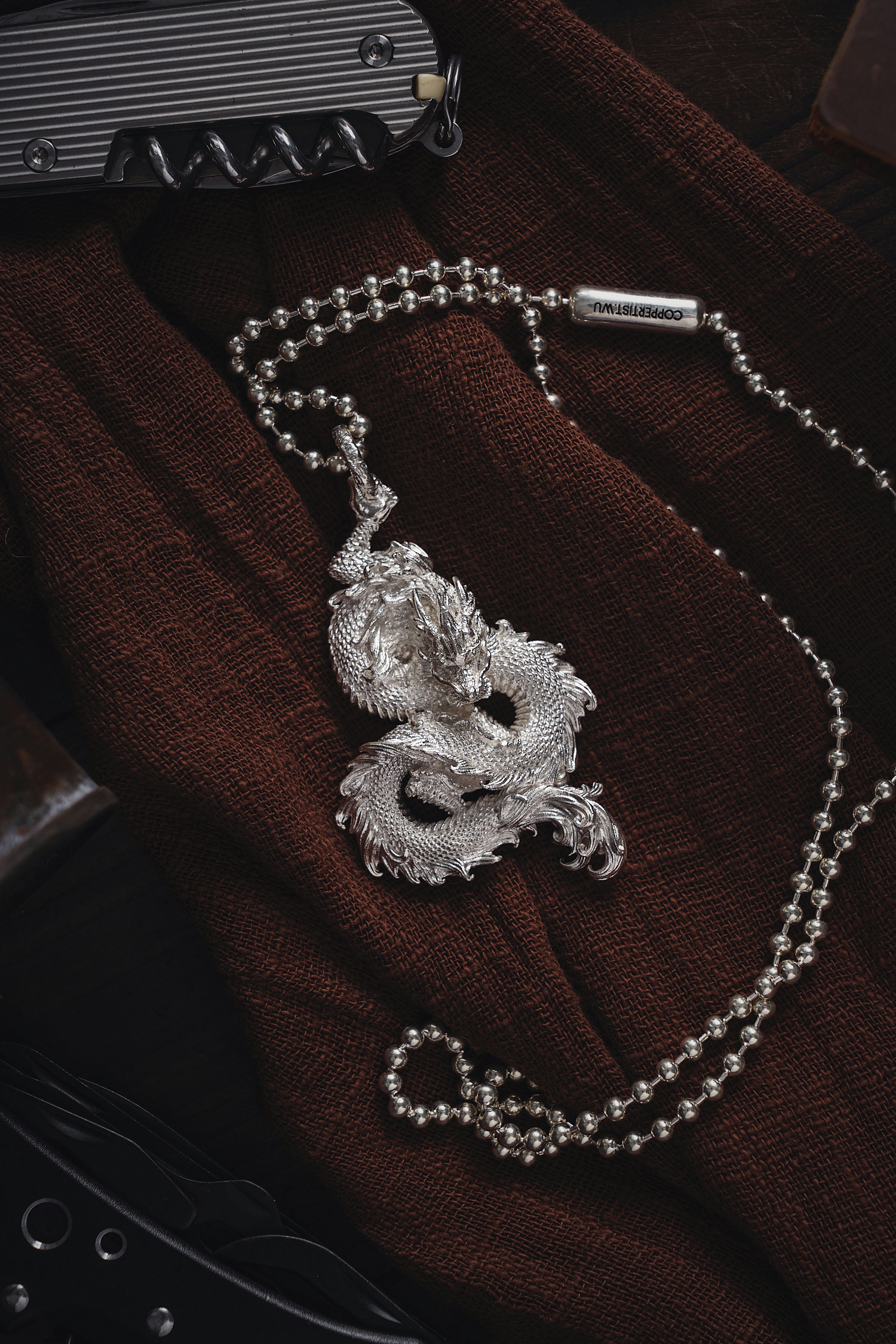 A chain with a silver dragon on it photo – Free Jewelry Image on Unsplash