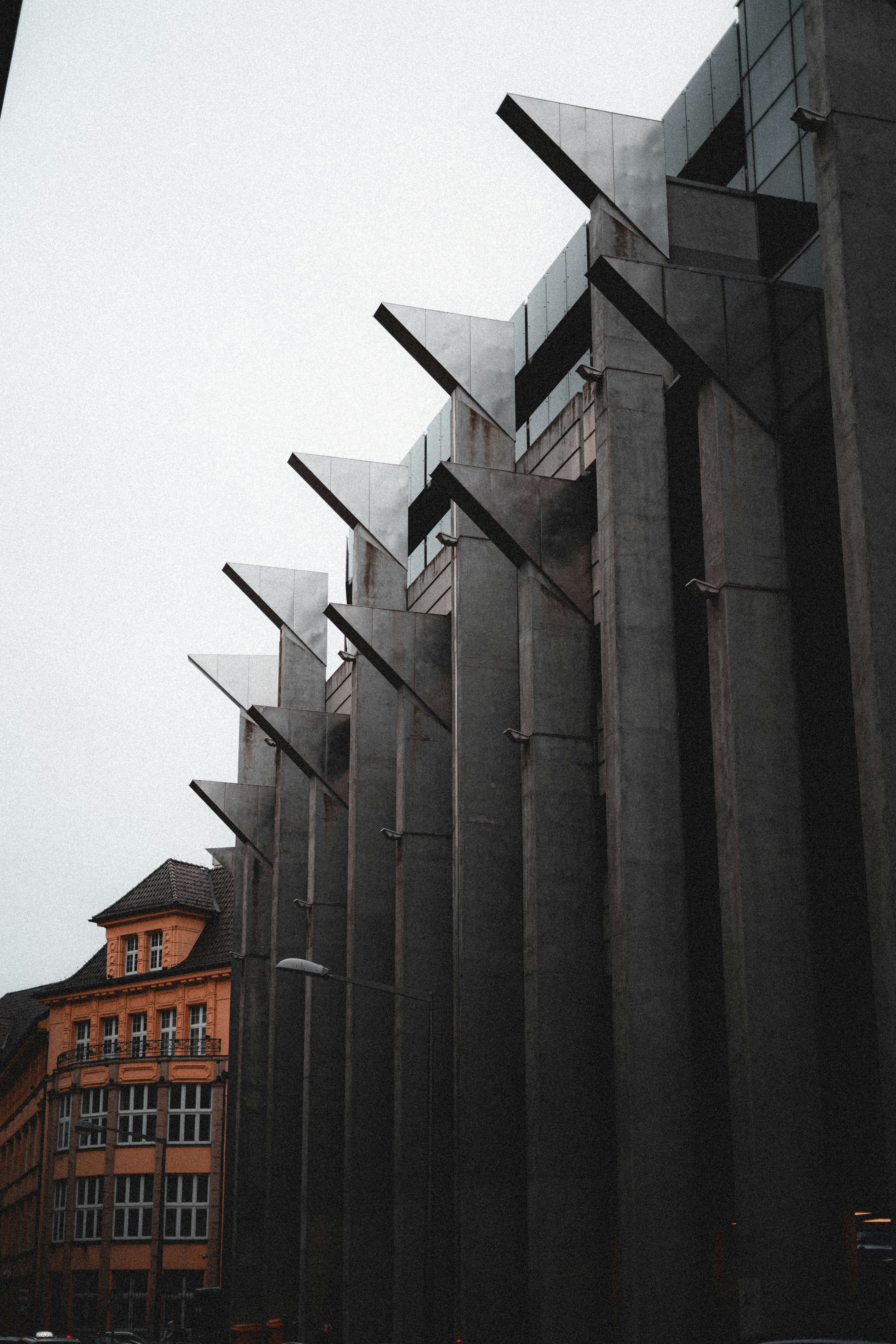 Concrete Facade Echoes: A Row of Angular Shadows Against a Historic Street