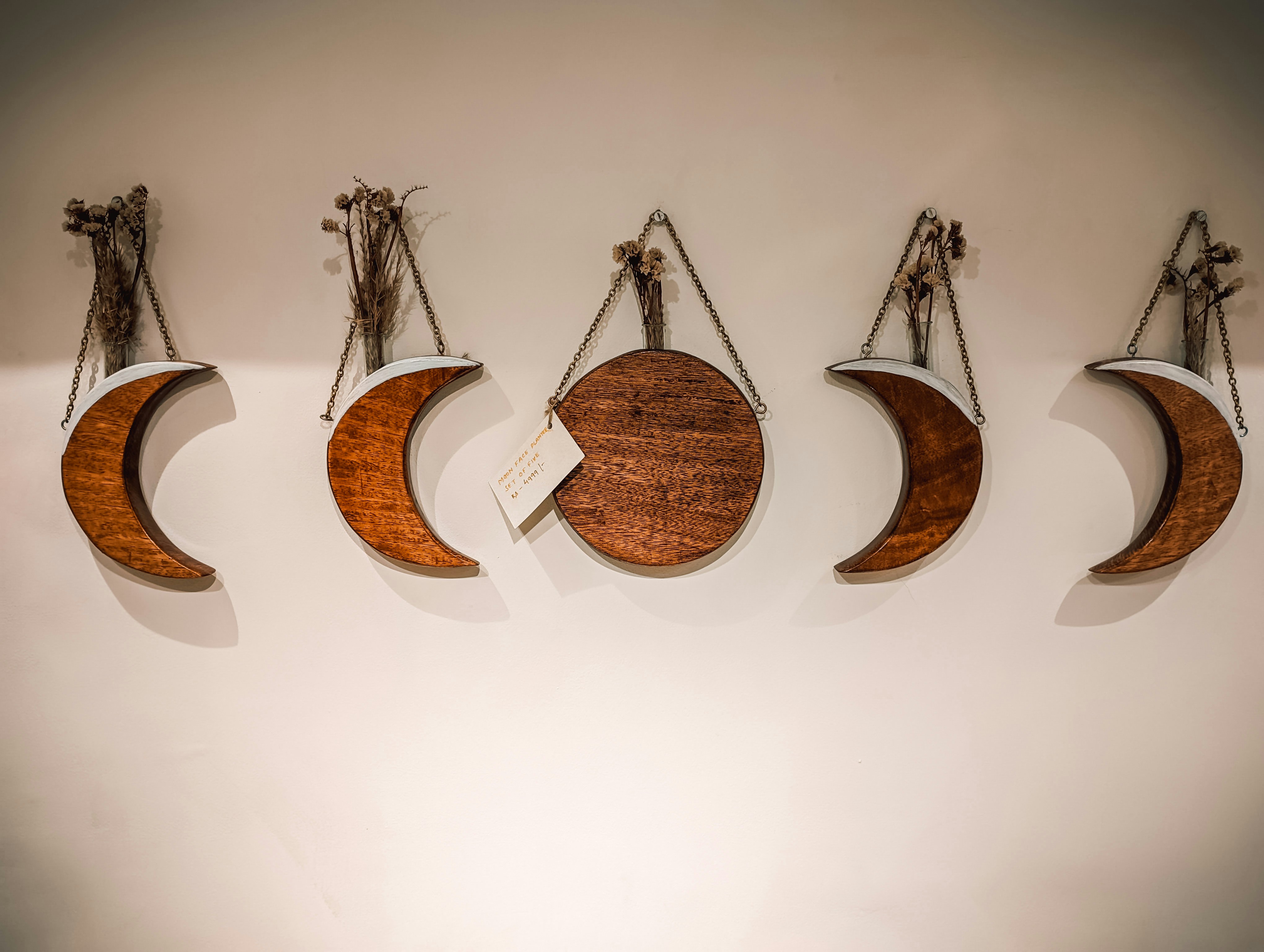 a group of three wooden moon clocks hanging on a wall
