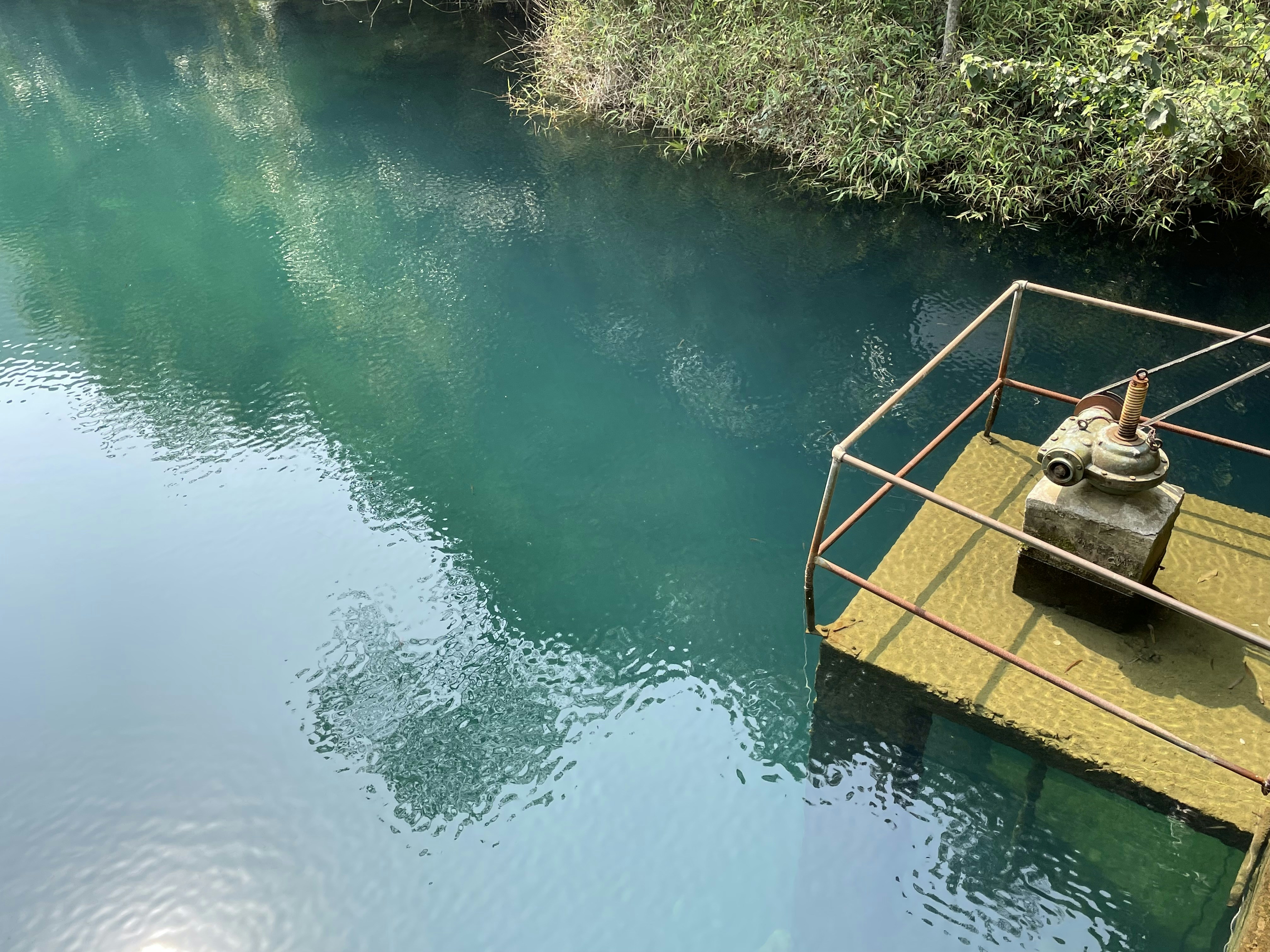 A man is sitting on a platform in the water photo – Free Ziyun valley ...