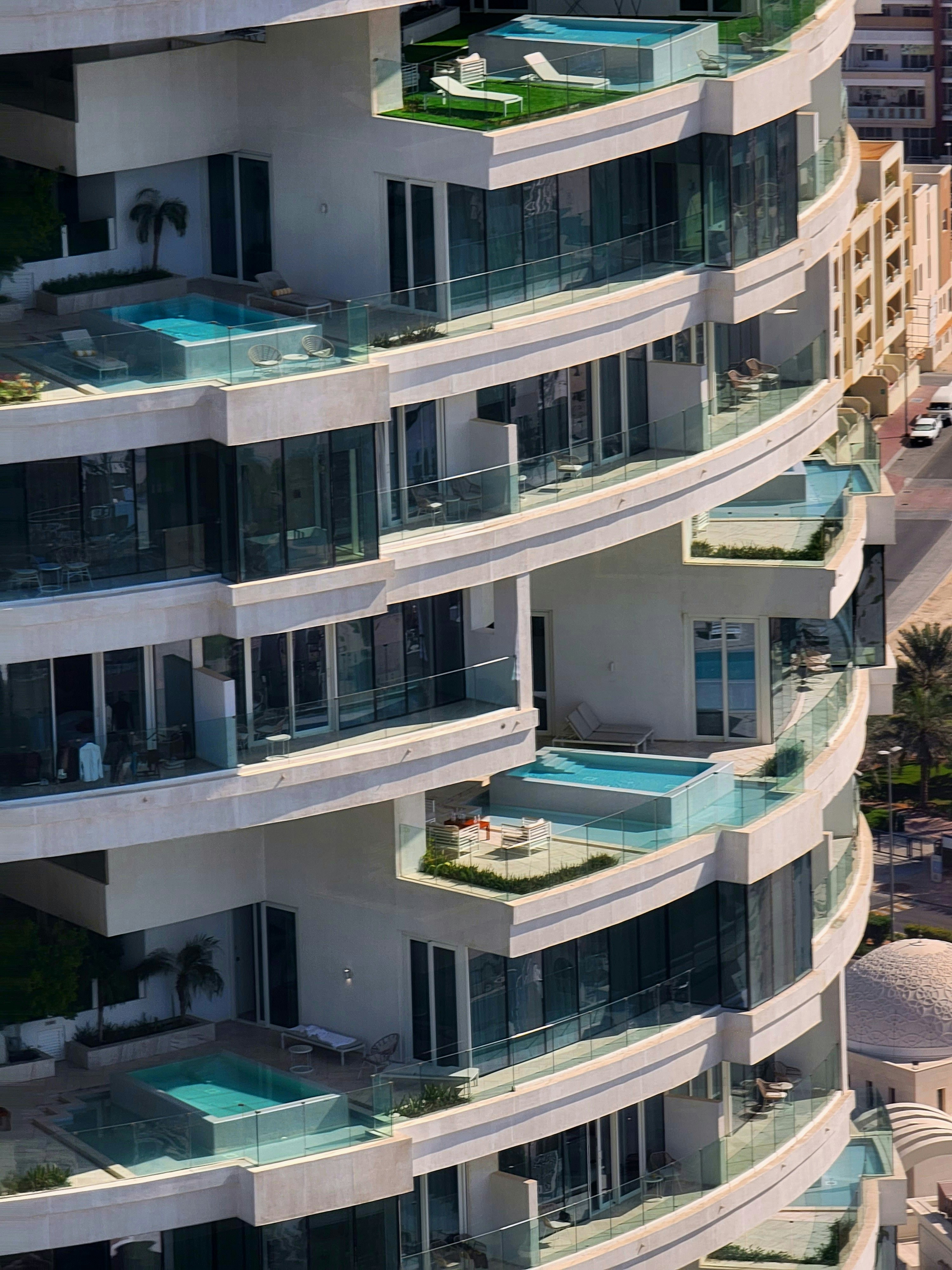 A very tall building with balconies and a swimming pool photo – Free ...