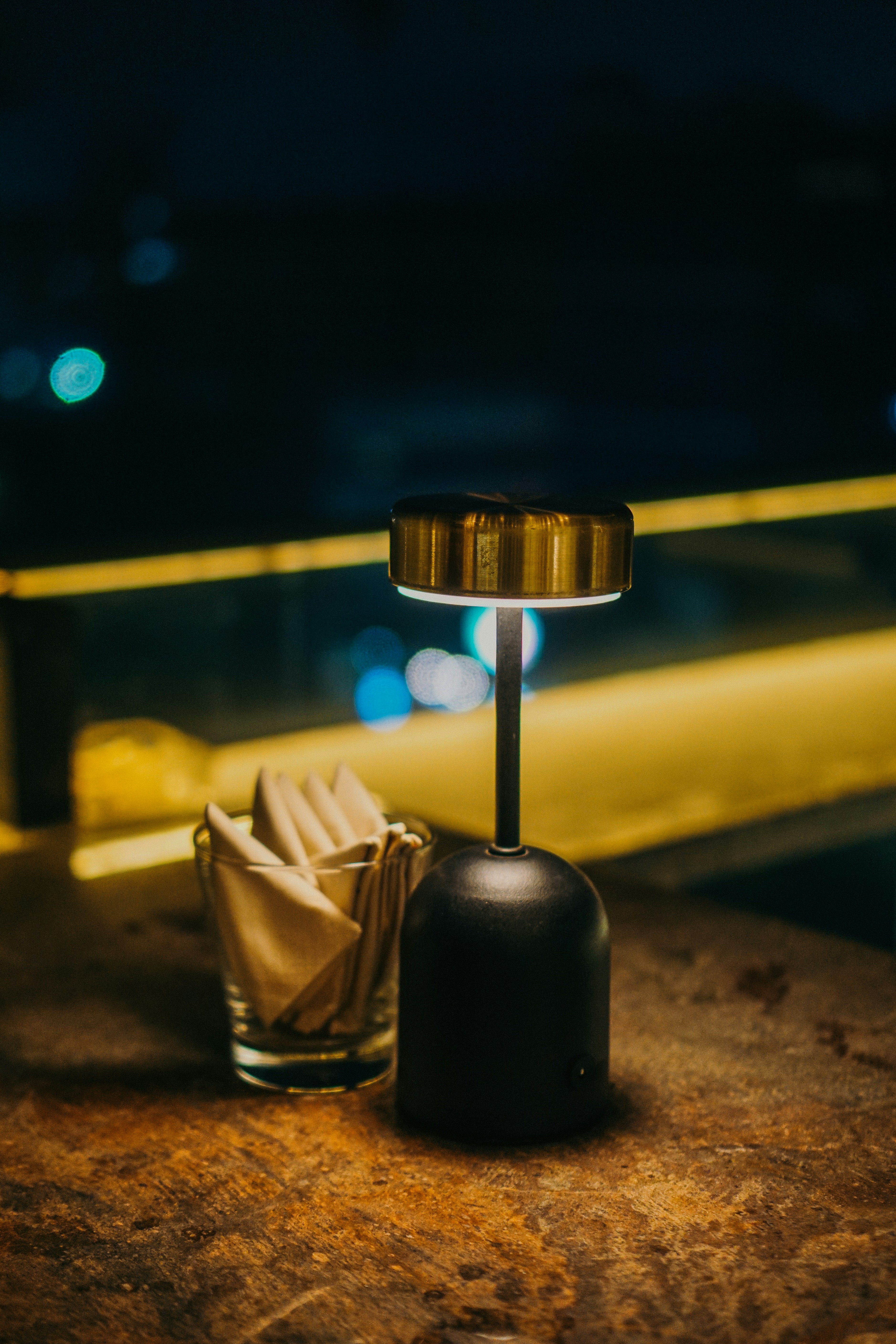 Warm Lamp on a Weathered Table: Nighttime Quiet in Neon Glow