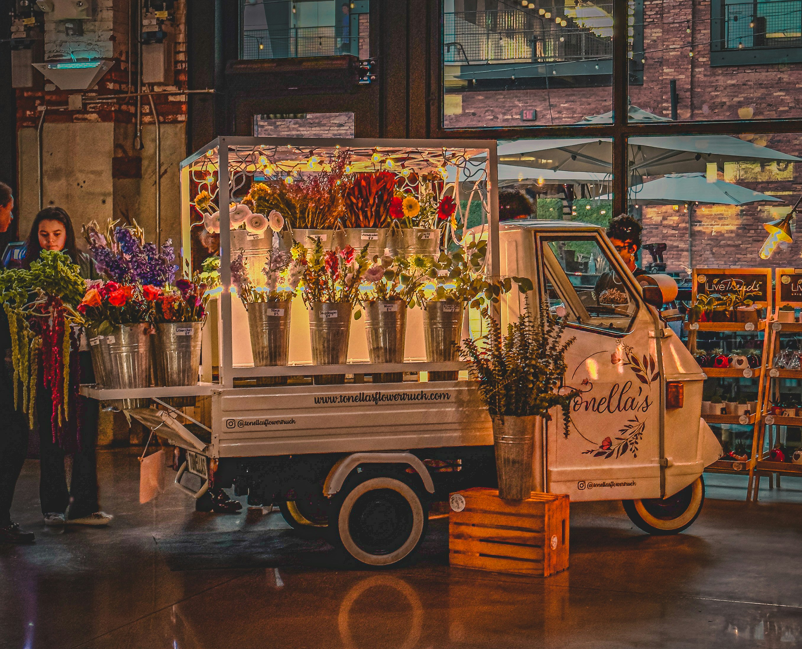 Floral Cart at Night: Neon Bloom Beneath Brick and Glass