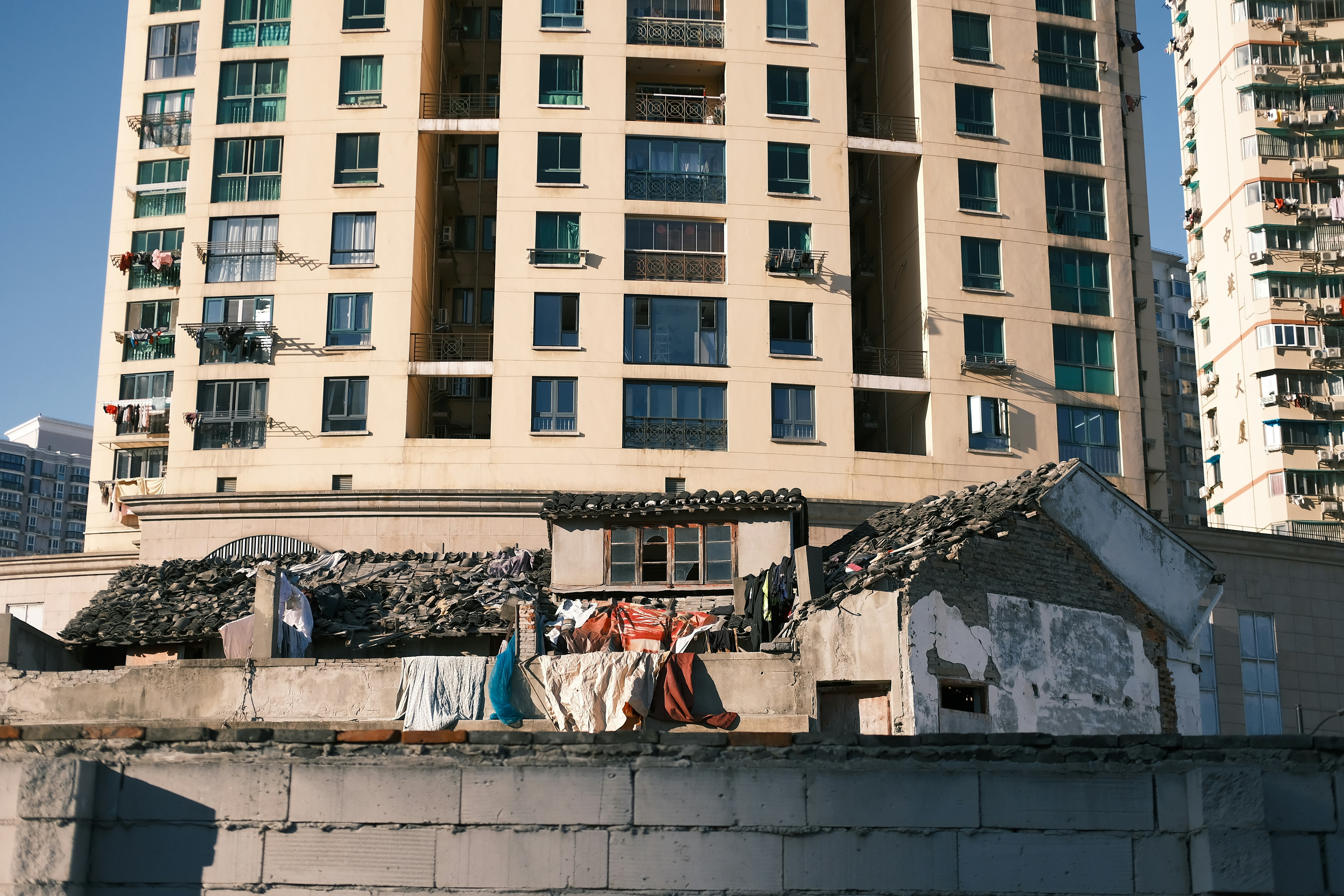 An old building that will be torn down is standing in front of a new building.