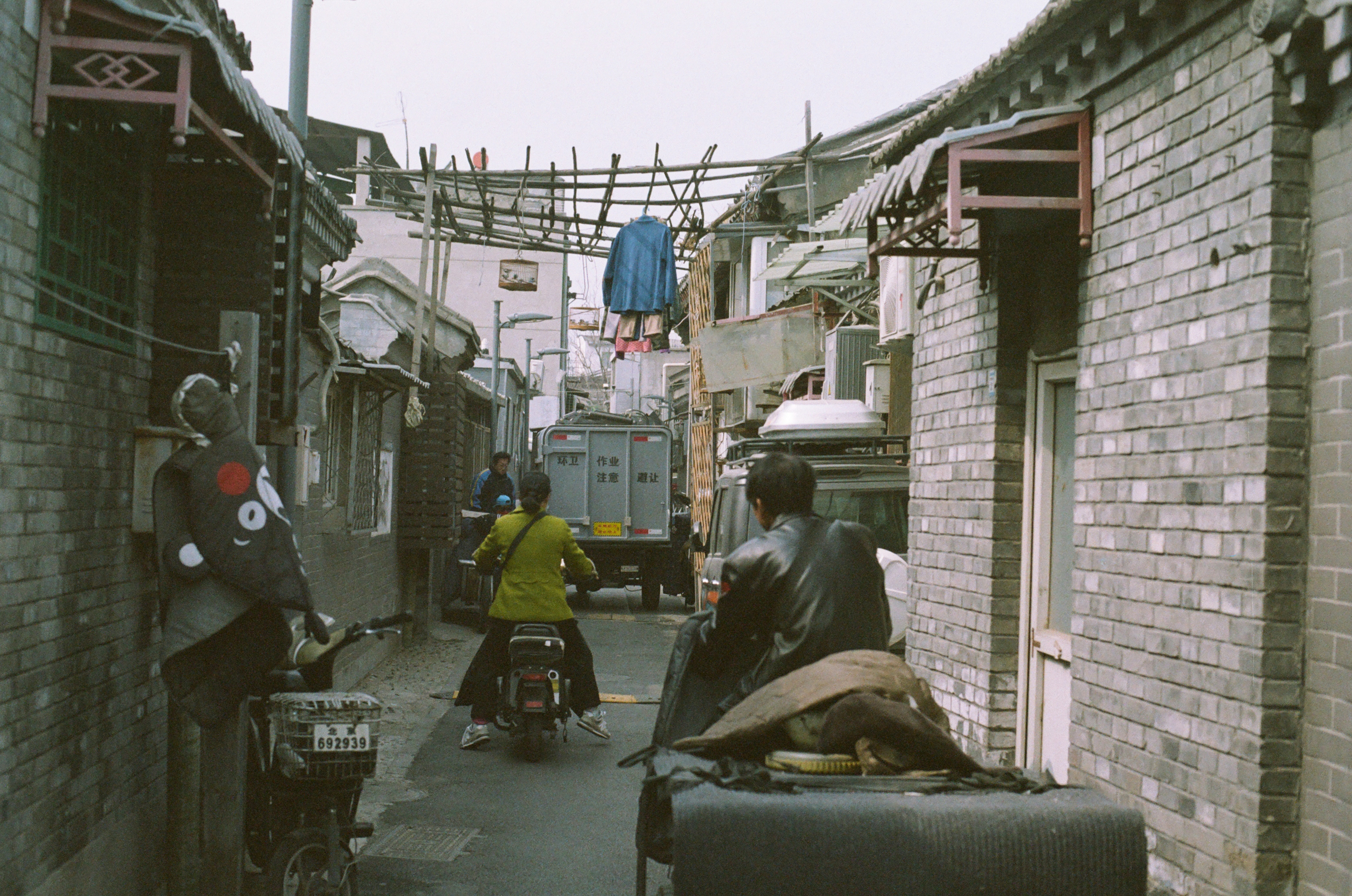 Midstreet Pulse: A Narrow Alley Crowd Faces an Angular Sky