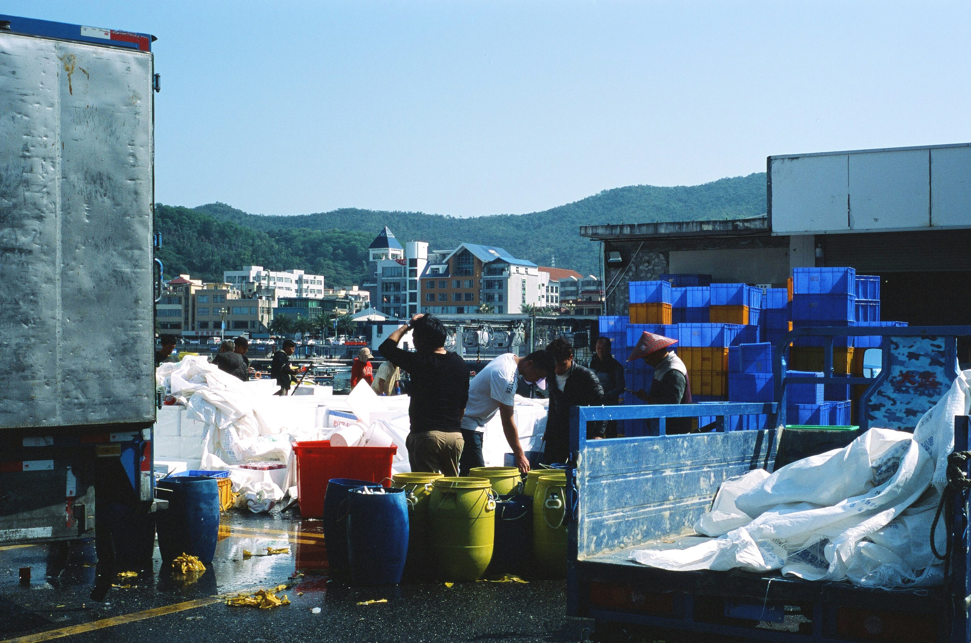 A group of people loading containers onto a truck photo – Free City ...