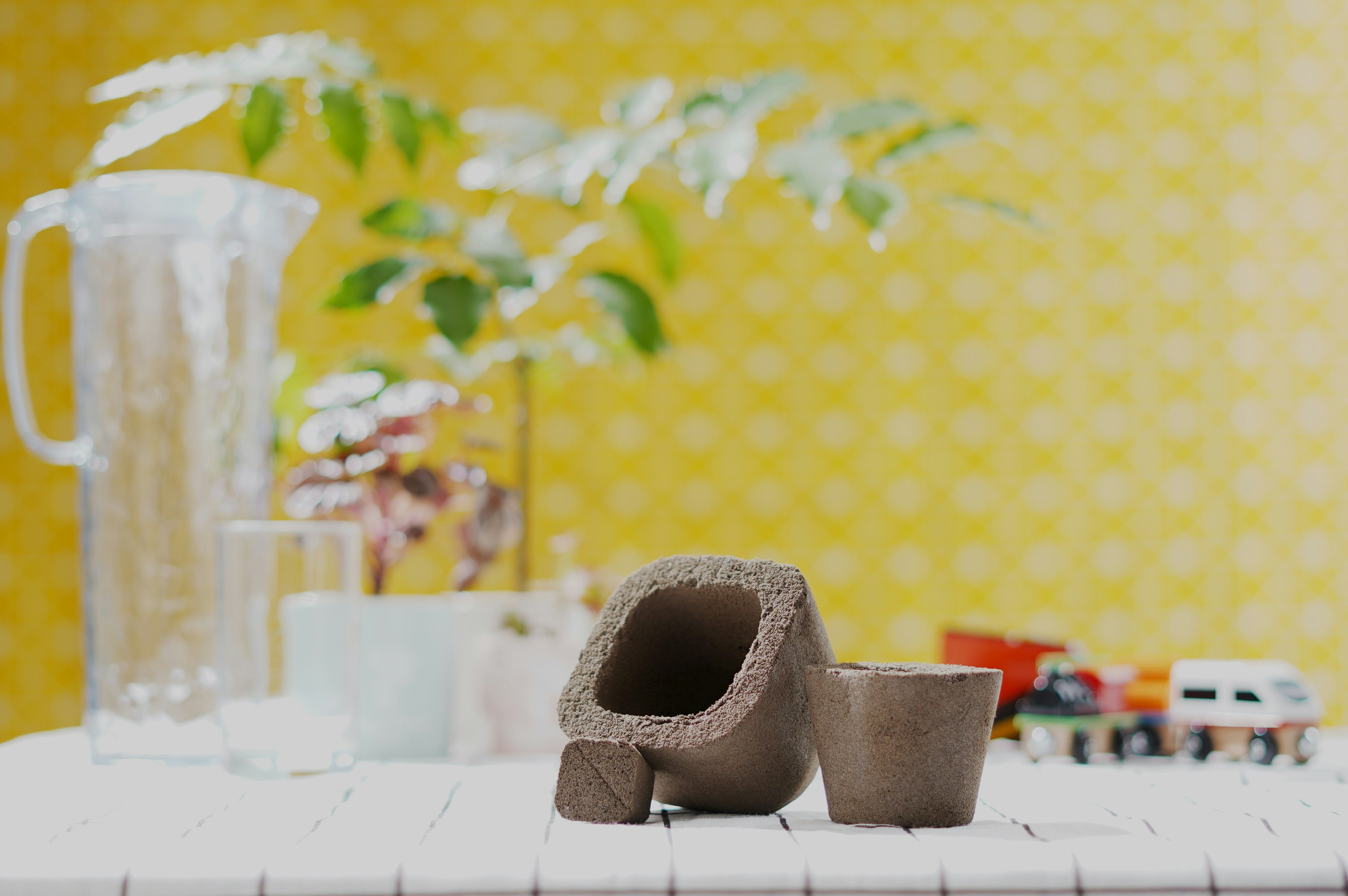 Sunlit Clay Pots on a White Slatted Table Against a Yellow Backdrop