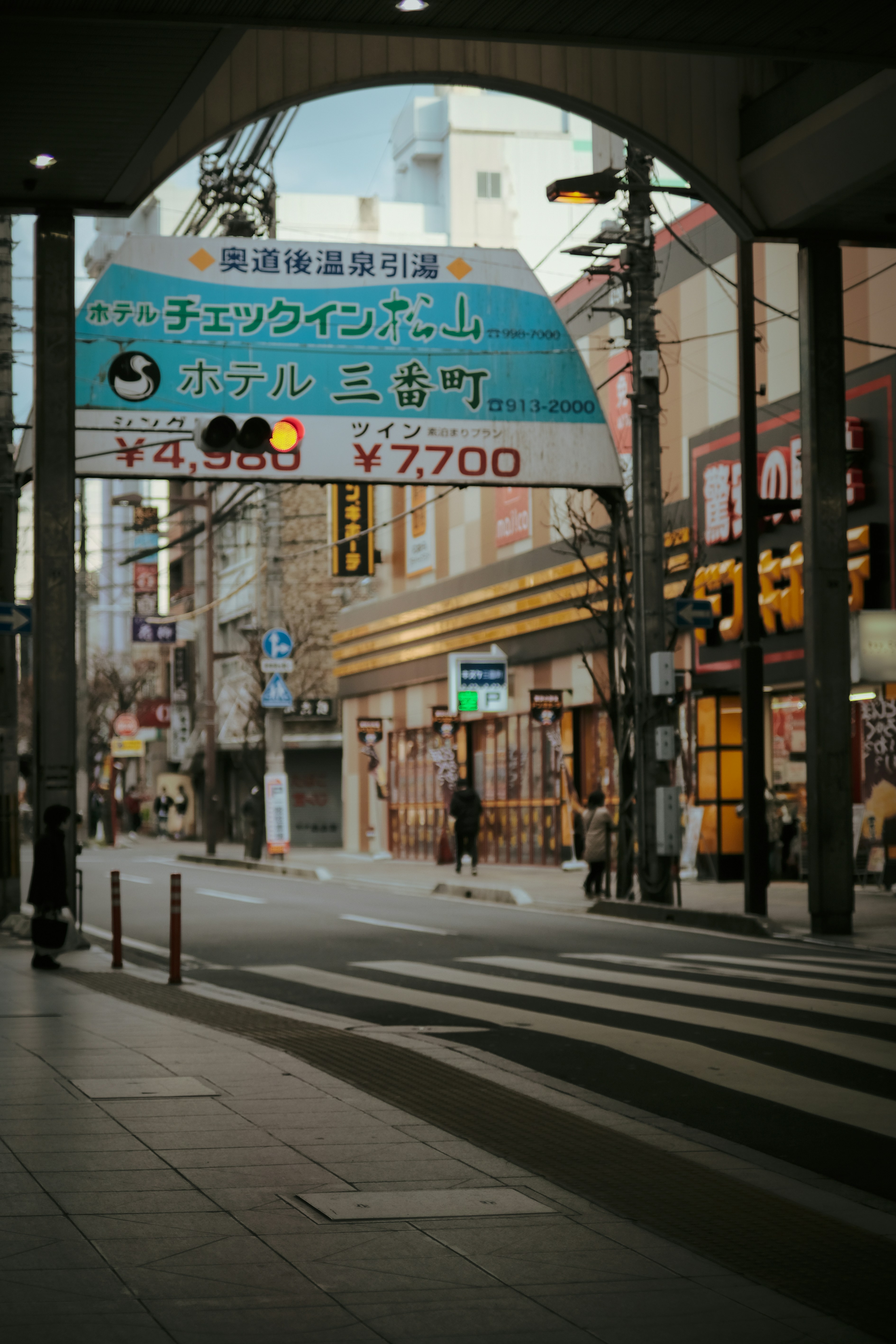 A city street with a large blue sign hanging from the side of it photo ...